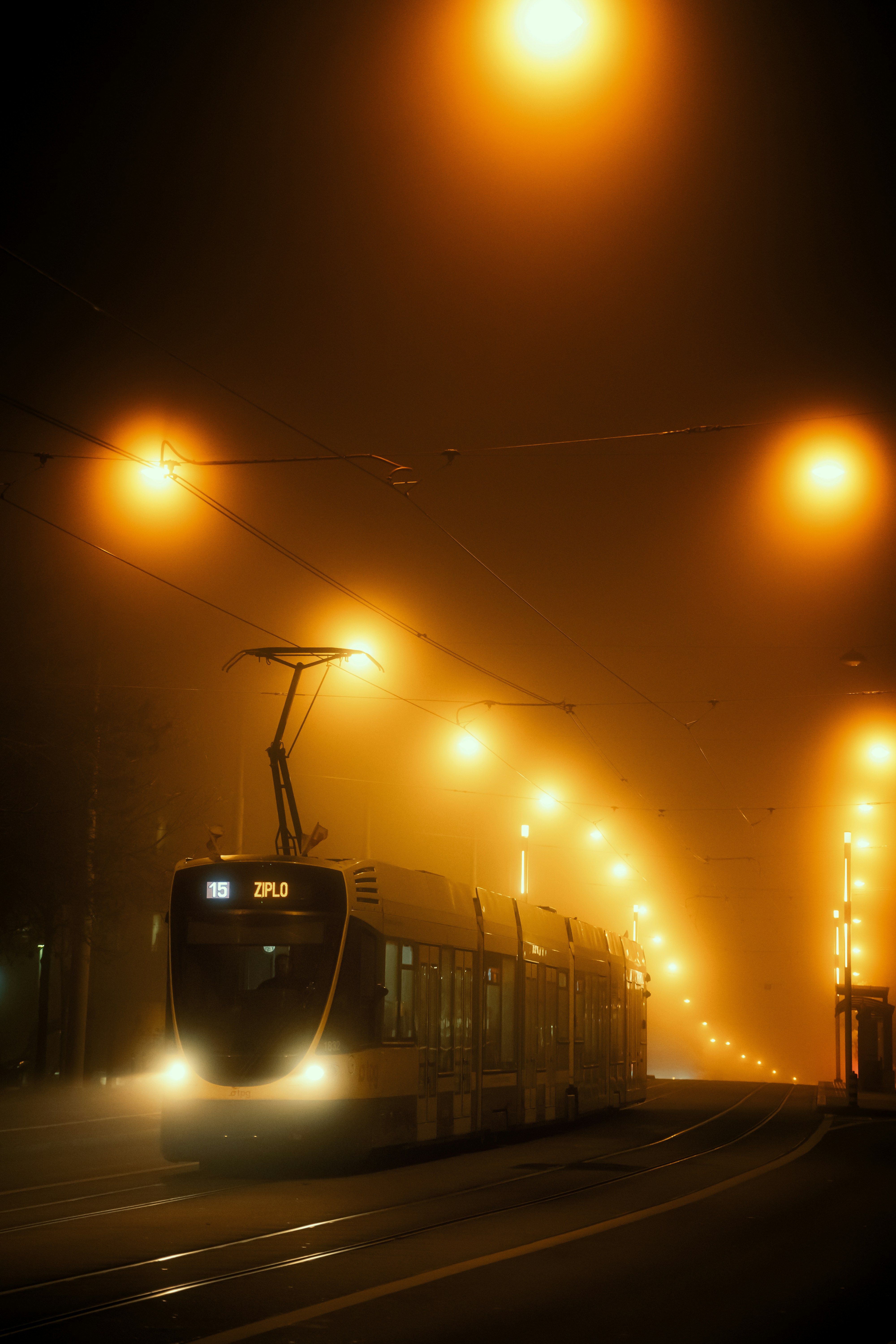 A train traveling down a foggy street at night photo – Free Geneva ...