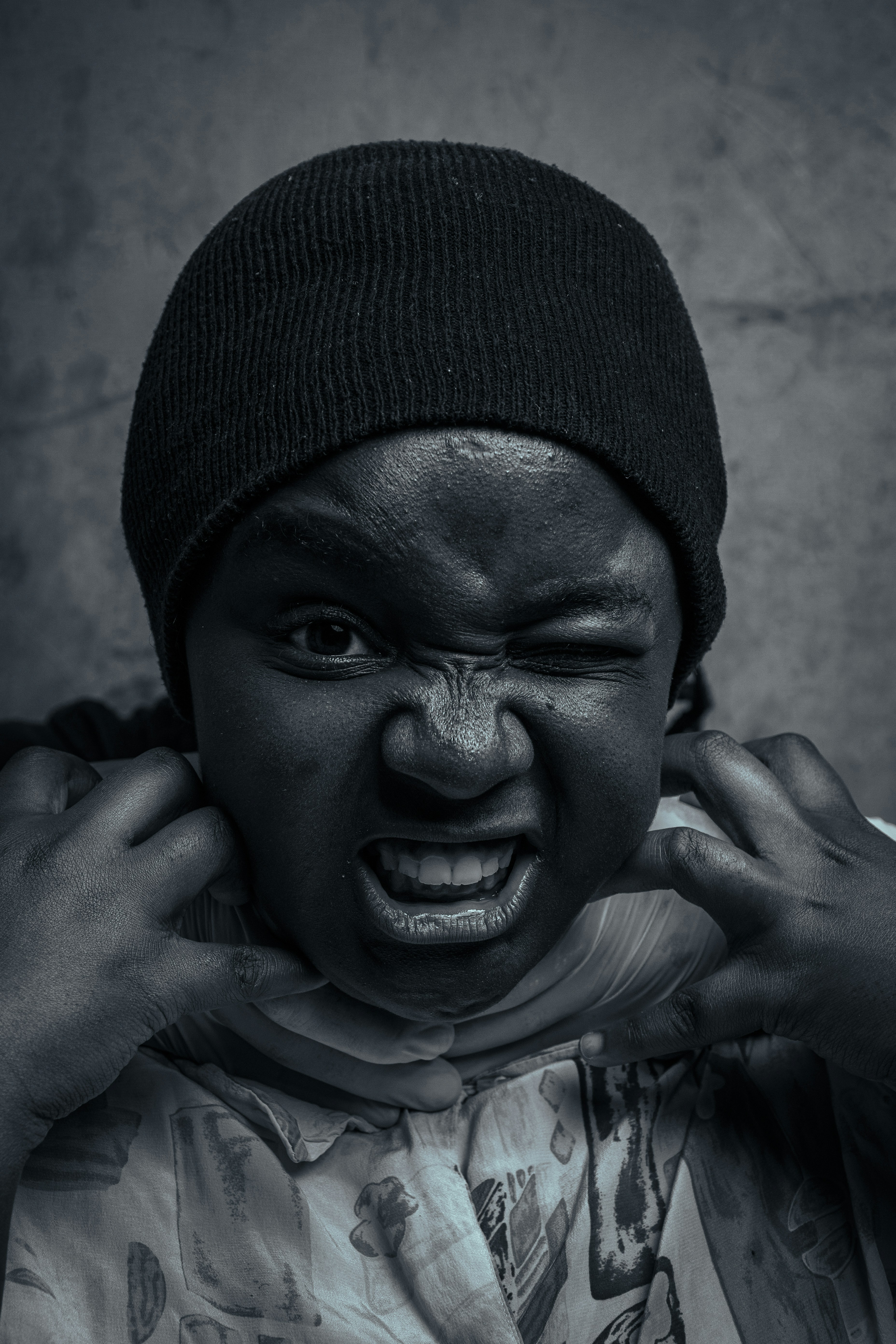 Beanie Fury: A monochrome close-up of a boy's confrontational expression