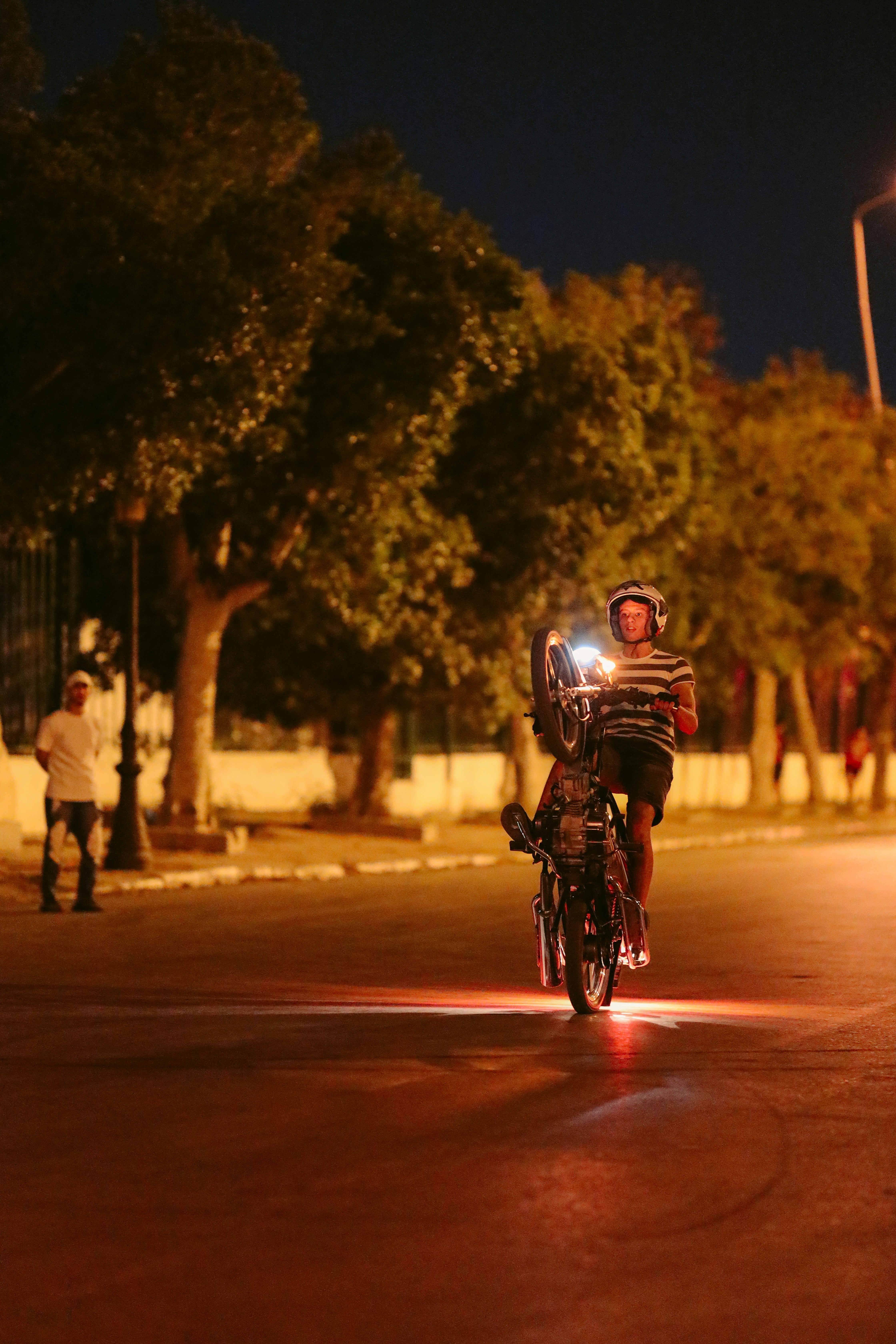 Midnight Wheelie under Amber Streetlights: A Lone Rider's Streetlight Show