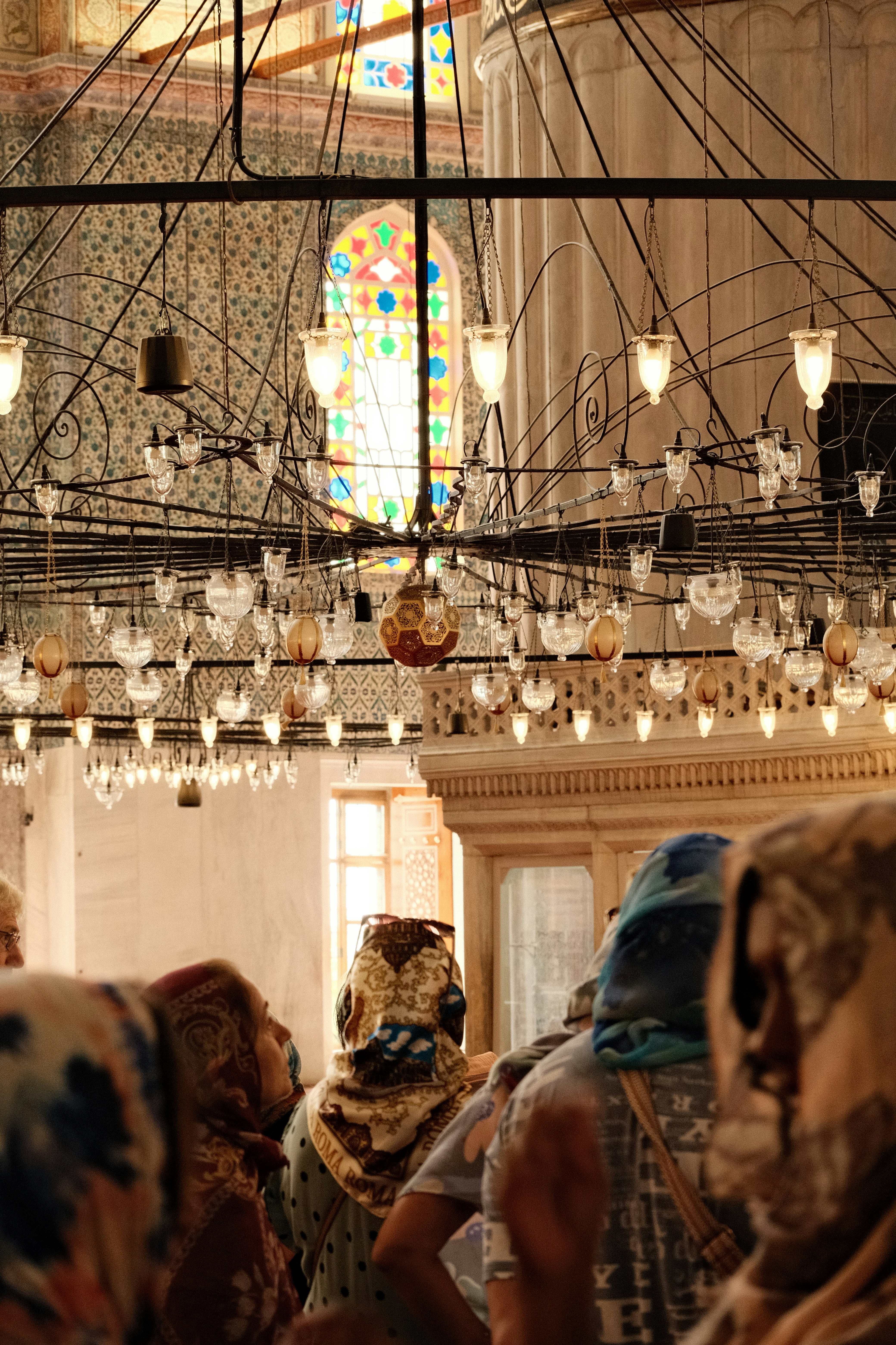 Stained-Glass Lightshow: A Sacred Hall Framed by a Web of Hanging Bulbs