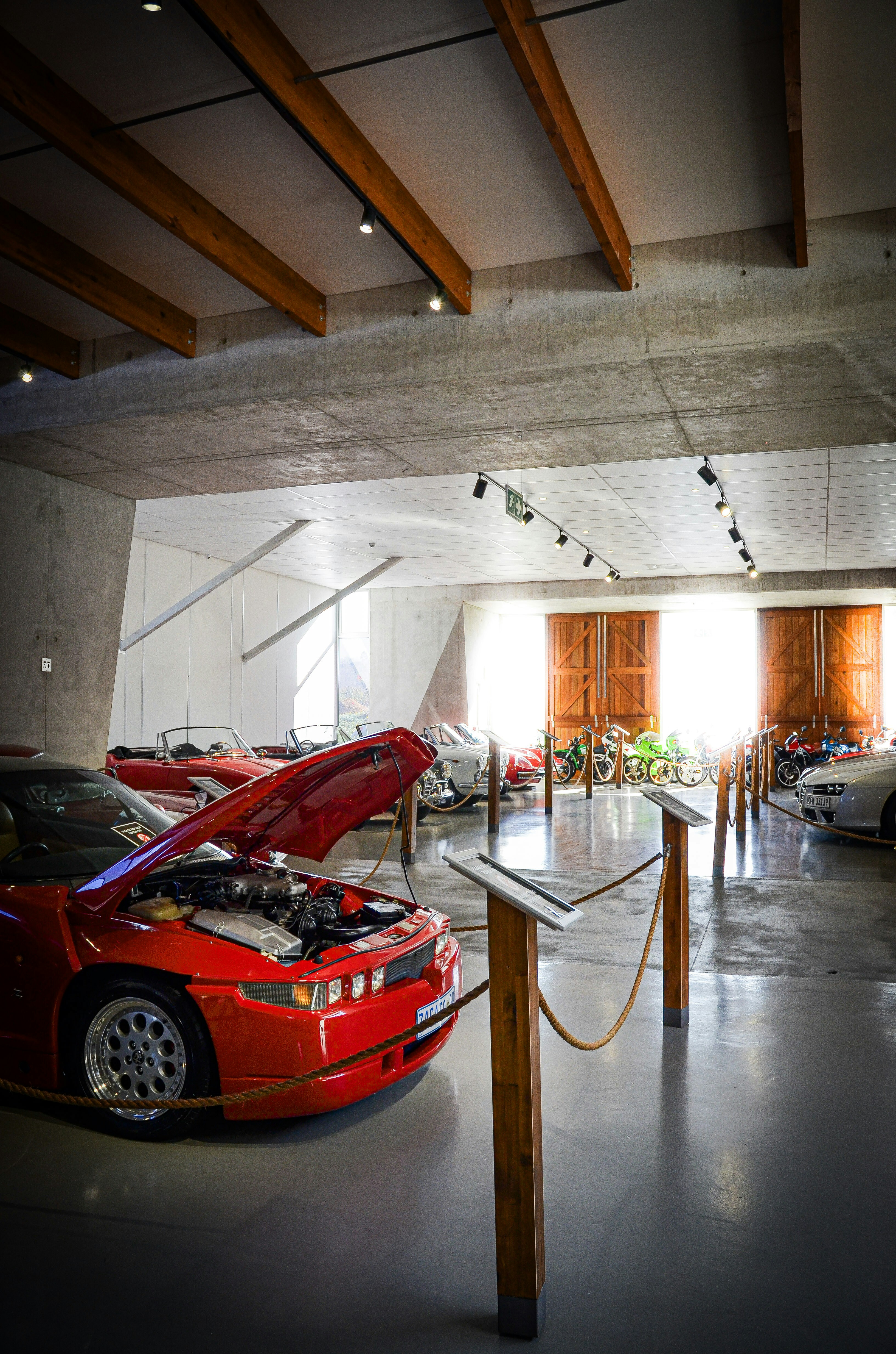Hood Up in a Concrete Car Vault: A Red Sports Car Amid Industrial Light