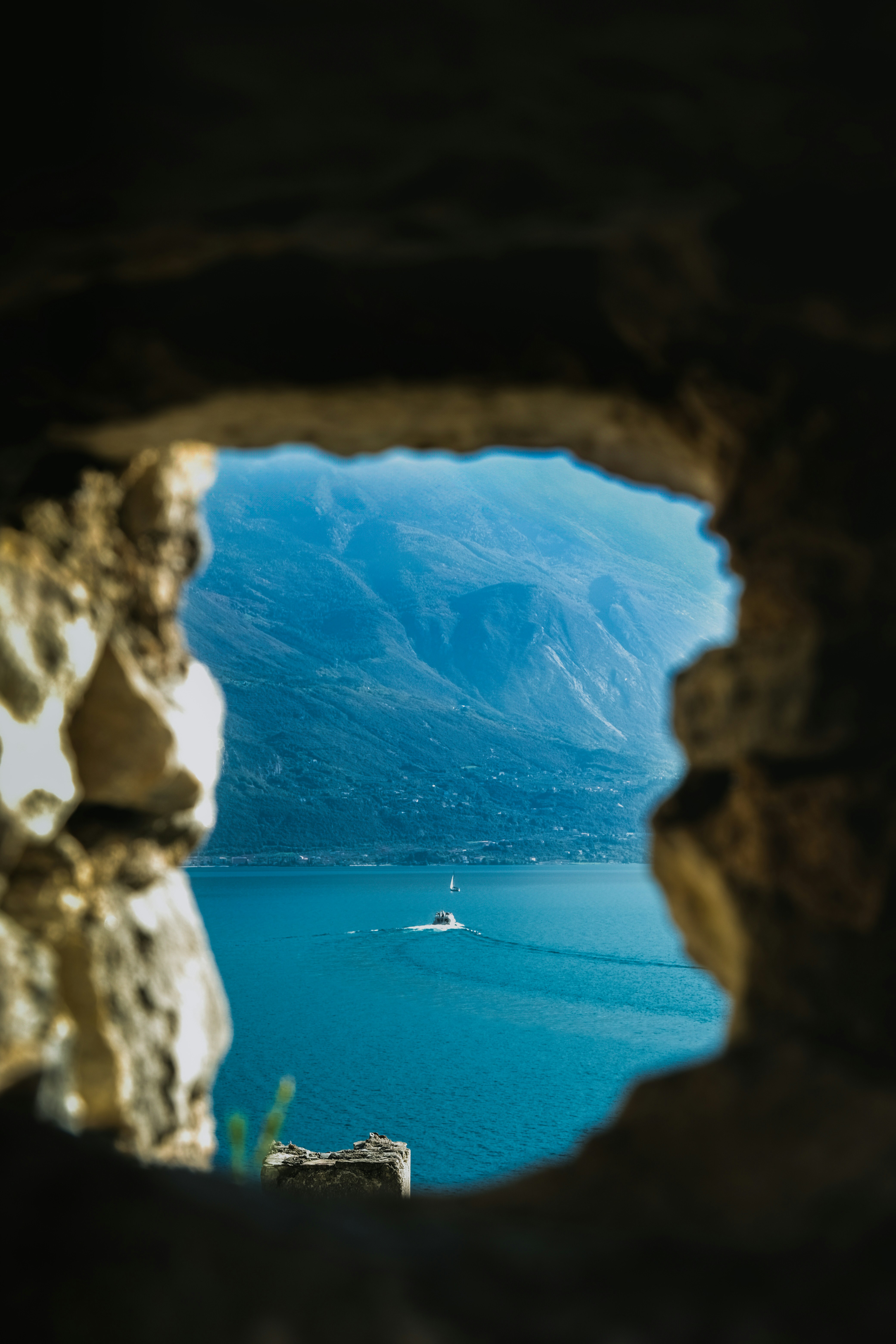 Frame Within a Frame: A Tiny Sailboat Crossing an Alpine Azure Lake