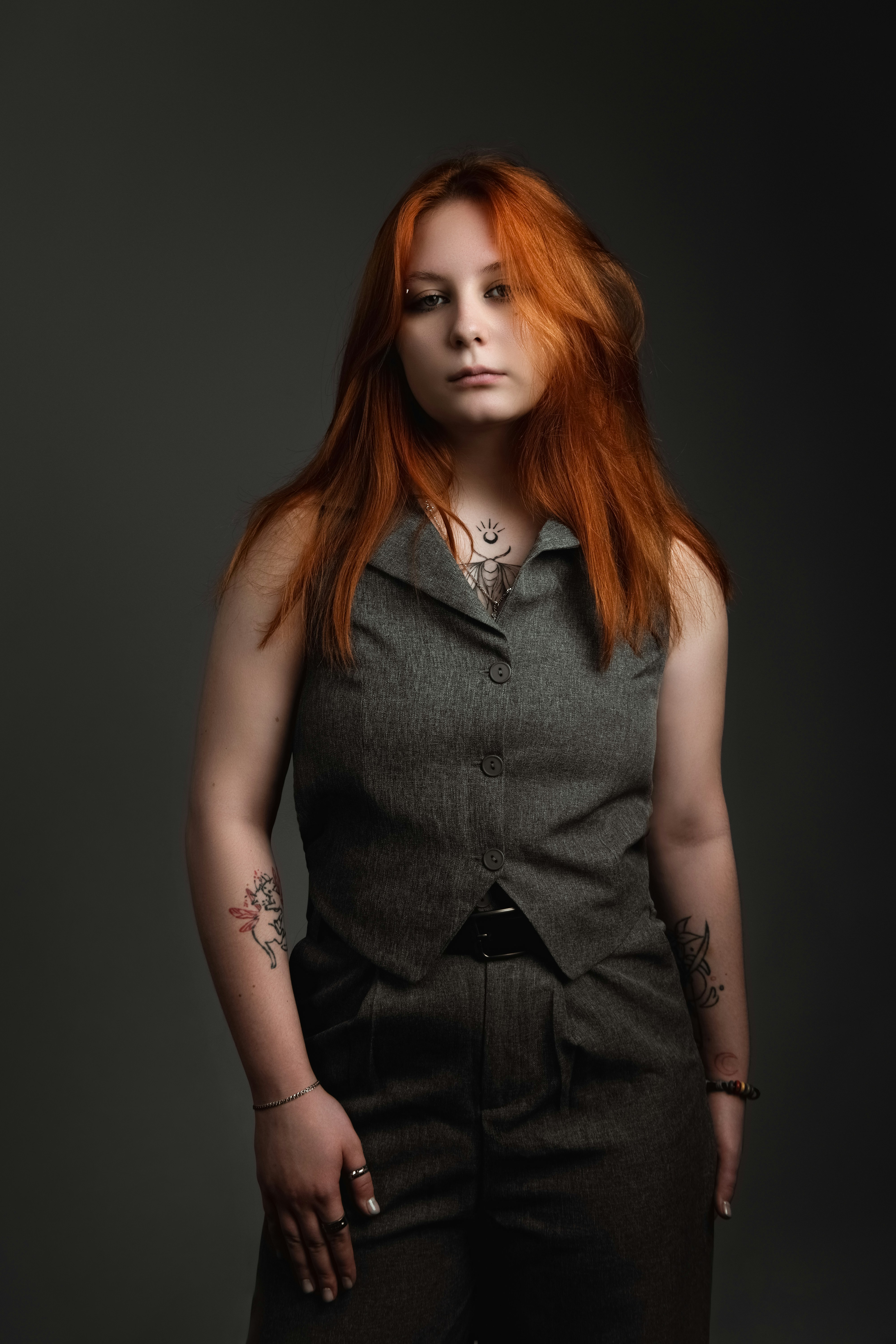 Ember in Grey: A Studio Portrait of Red Hair, Tattoos, and Quiet Power