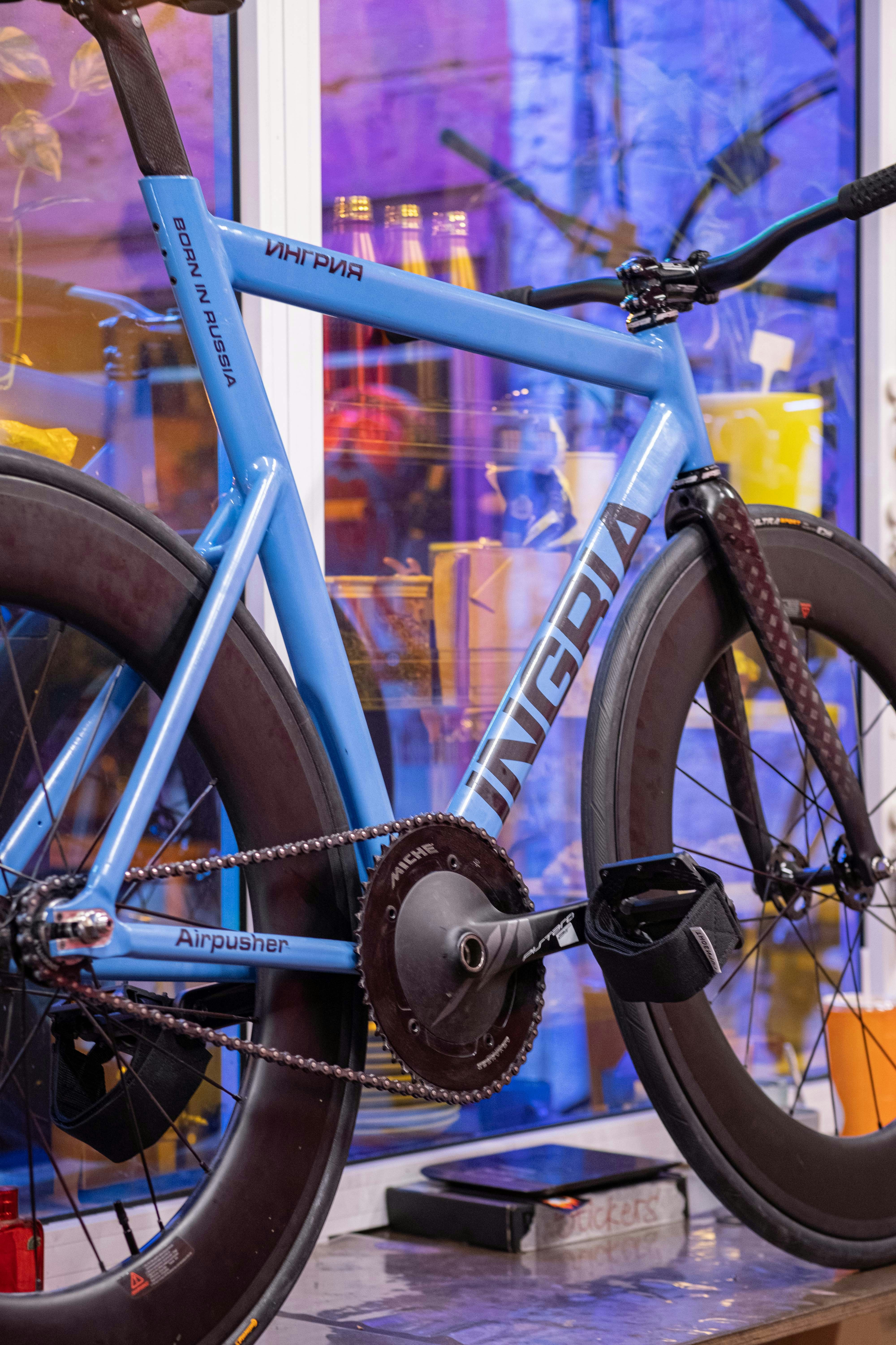 A blue bike parked in front of a store window