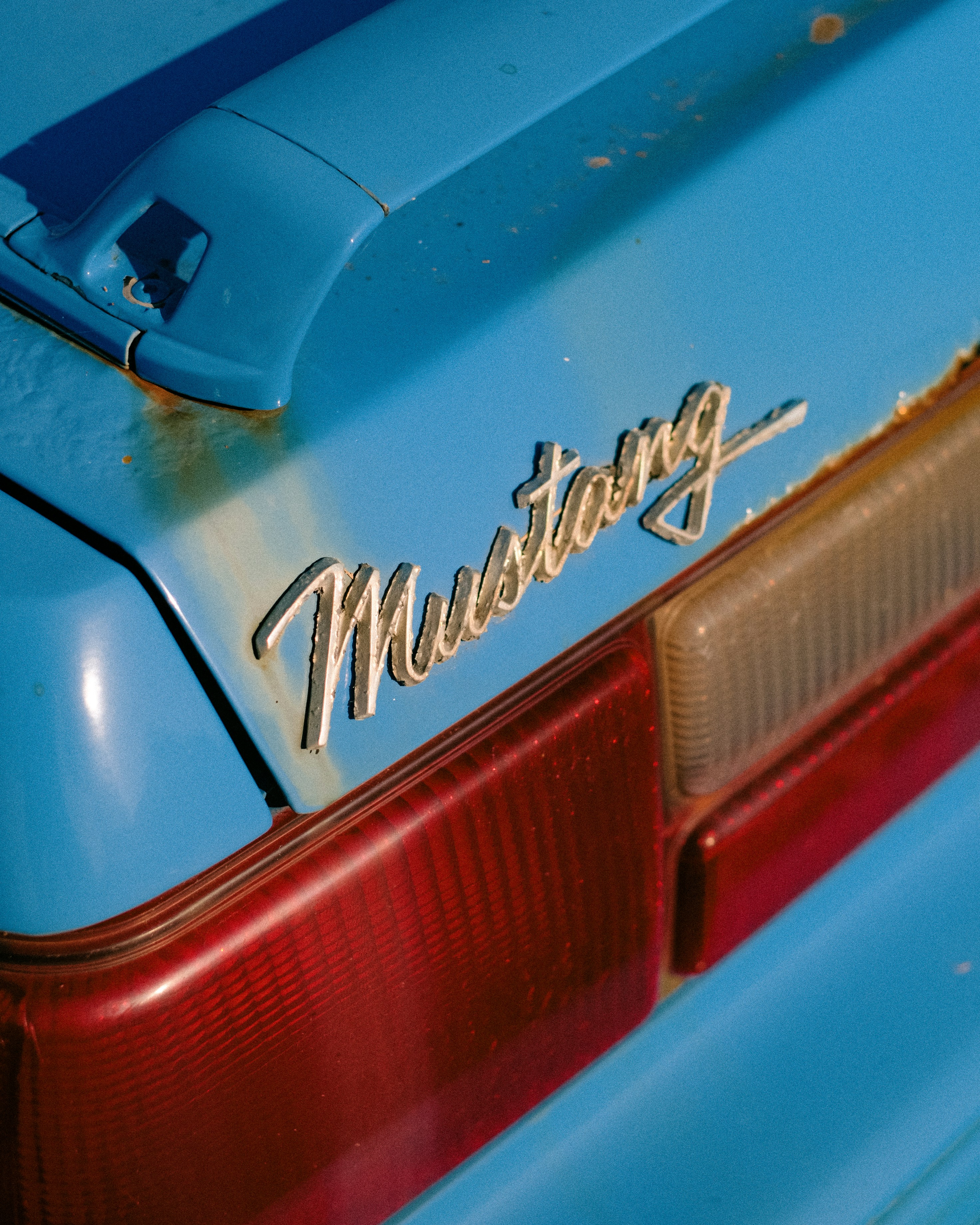 The tail end of a blue car with the word mustang on it photo – Free ...