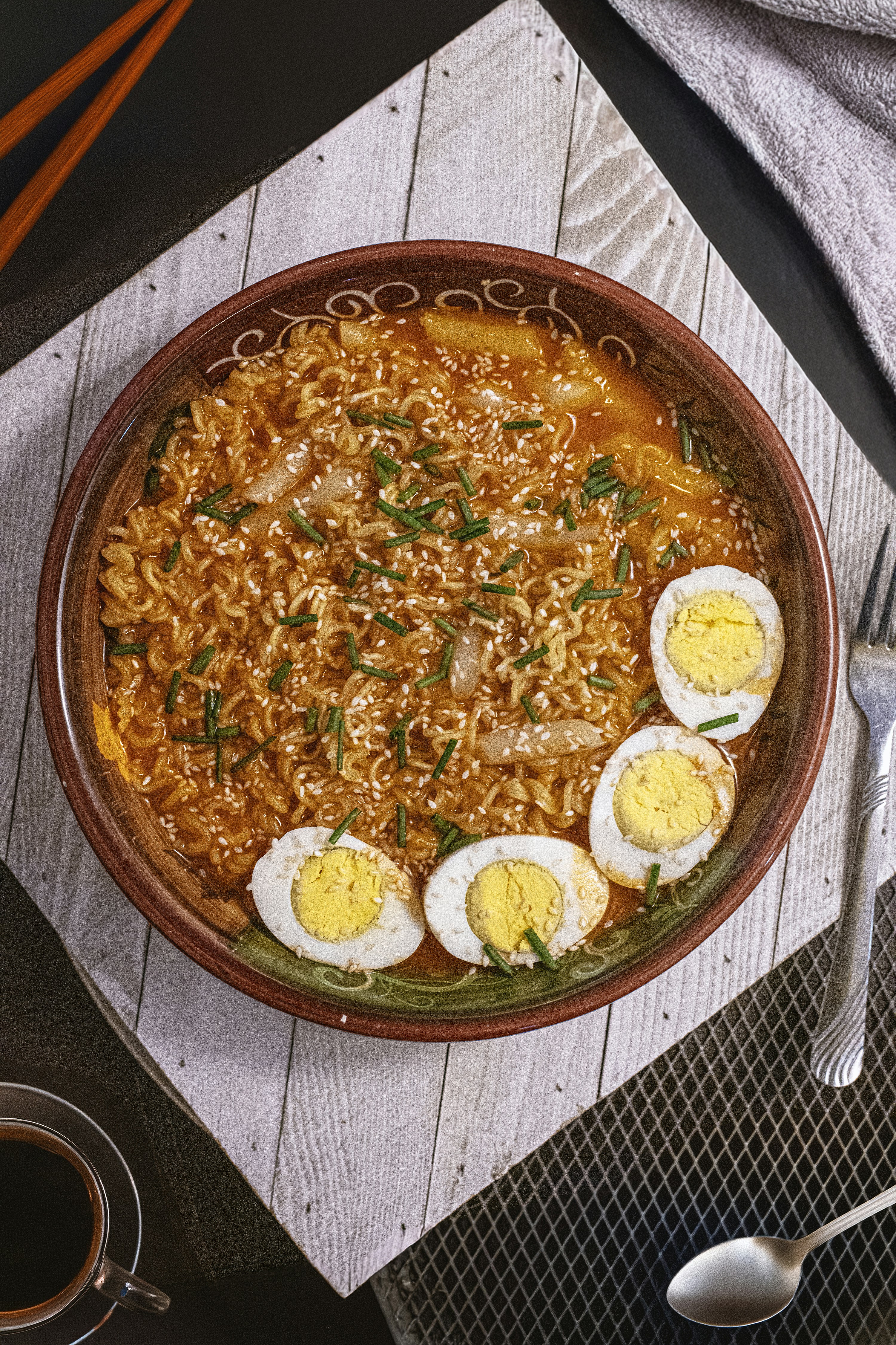 Spiced ramen in a ceramic bowl: eggs cradle a glossy, savory broth