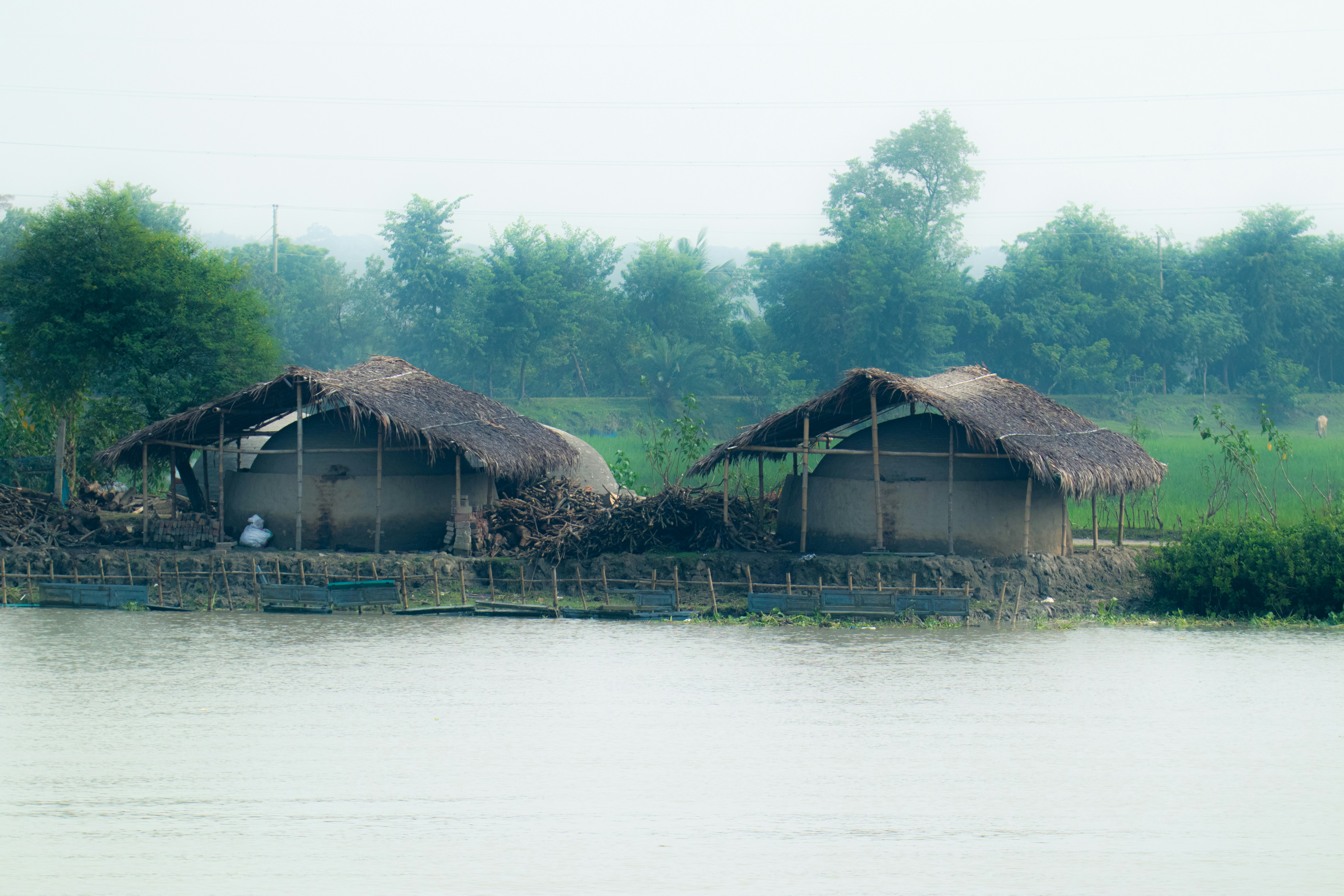 A group of huts sitting on top of a lake photo – Free River Image on ...
