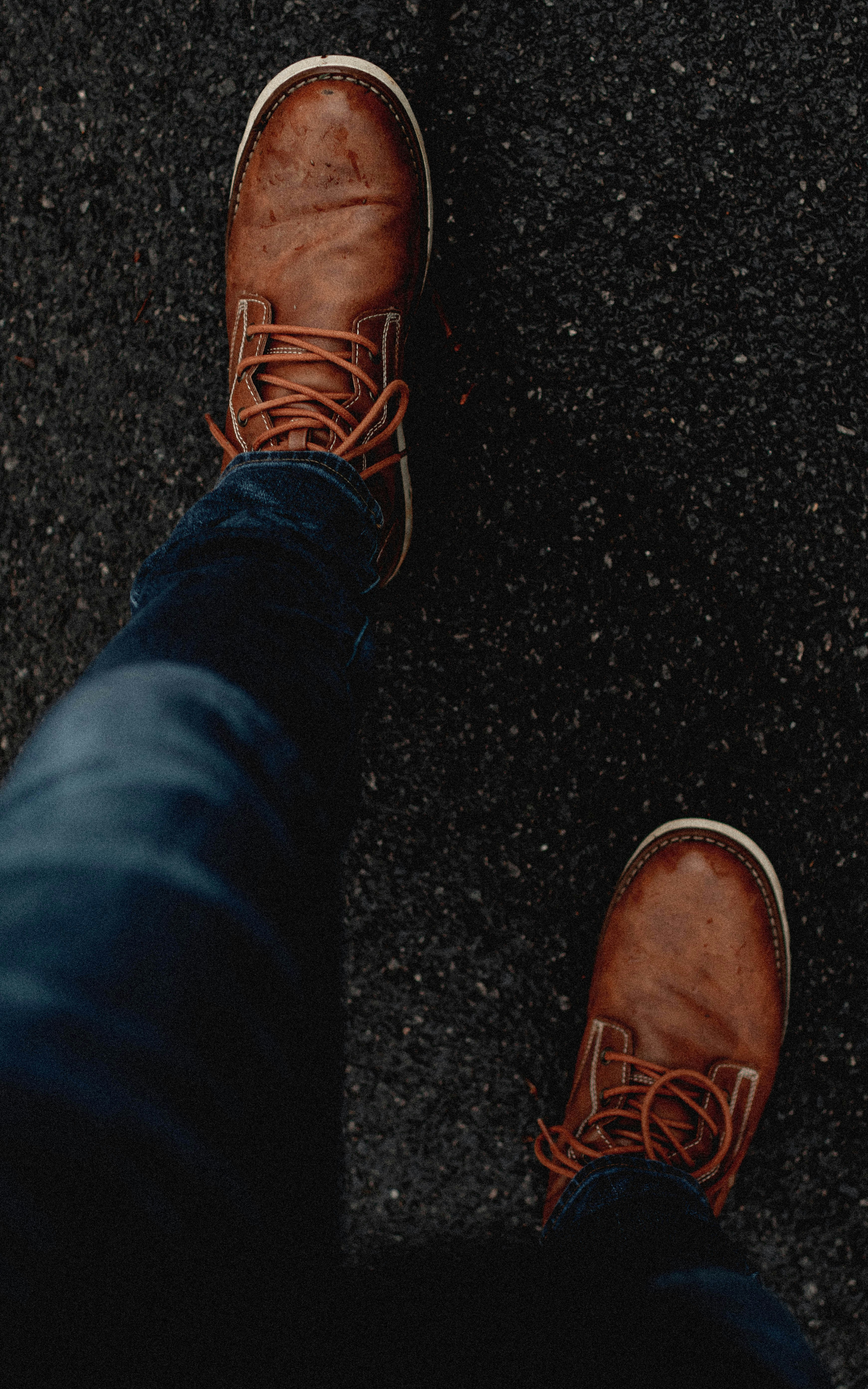 A person wearing brown shoes standing on a street photo – Free Man ...