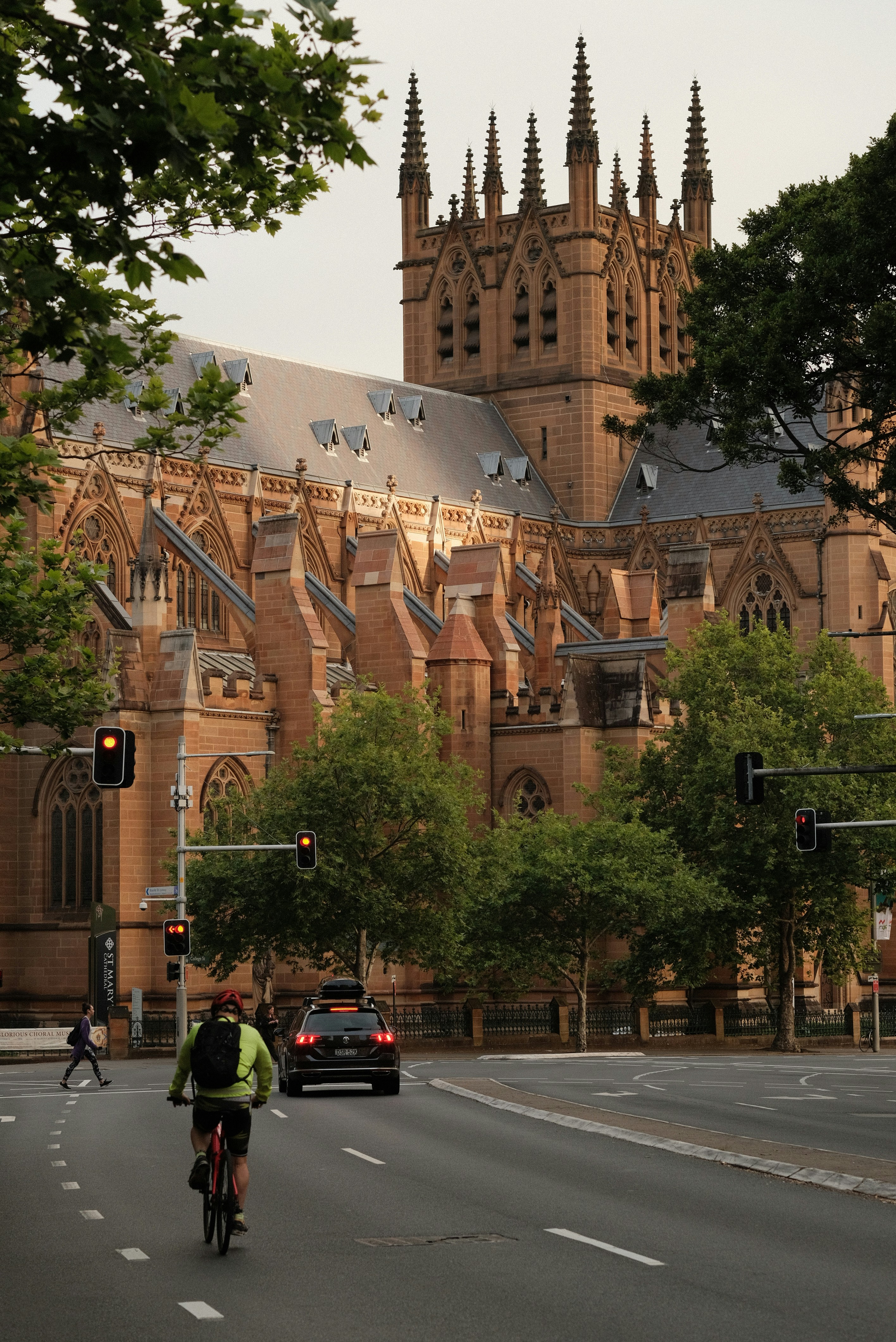 Spire Shadows: Cyclist and Gothic Grandeur on a City Street