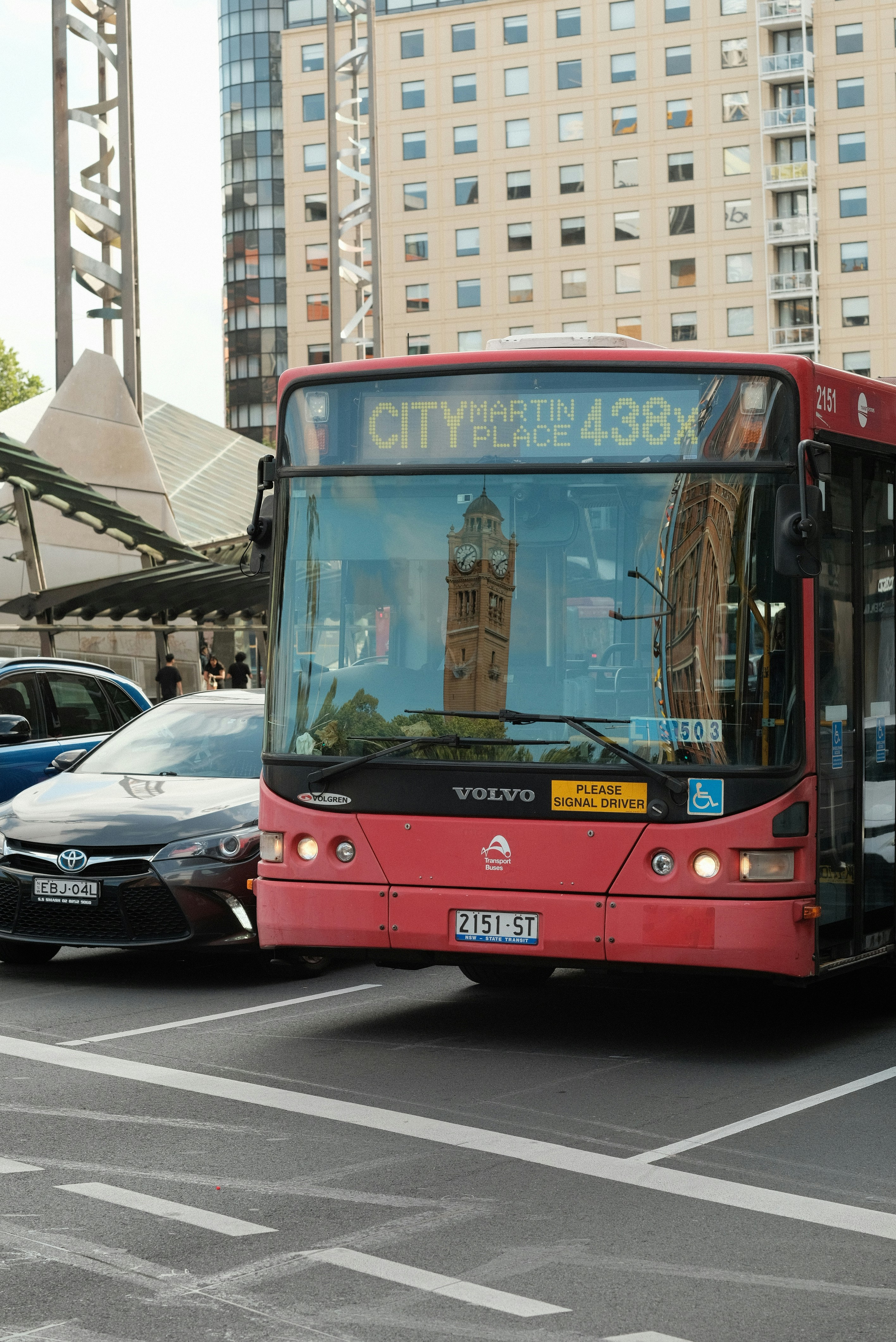Clock Tower Reflections on a Red City Bus Front
