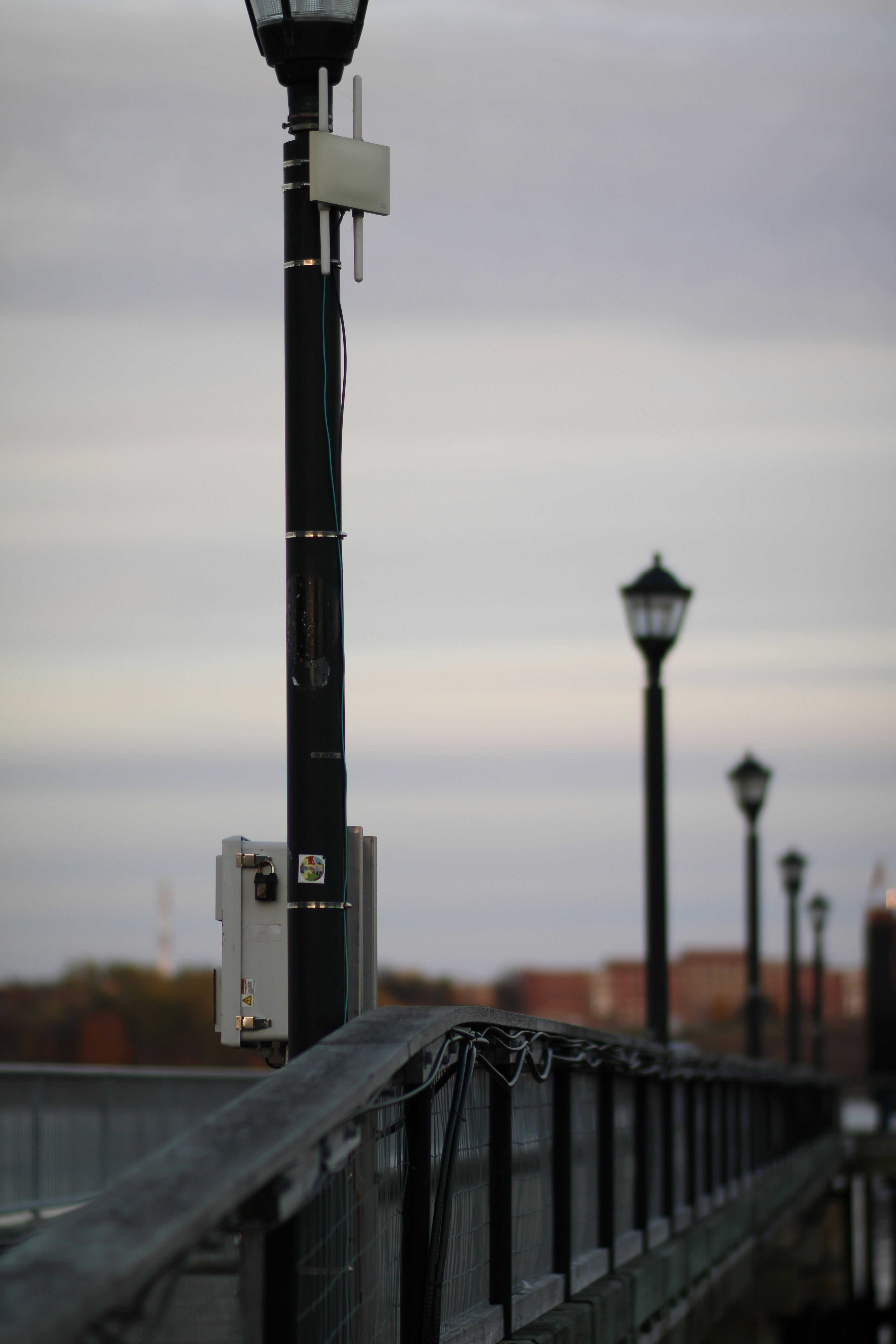 Lone Pier Lamp: A Quiet Walk Toward Distant Lanterns