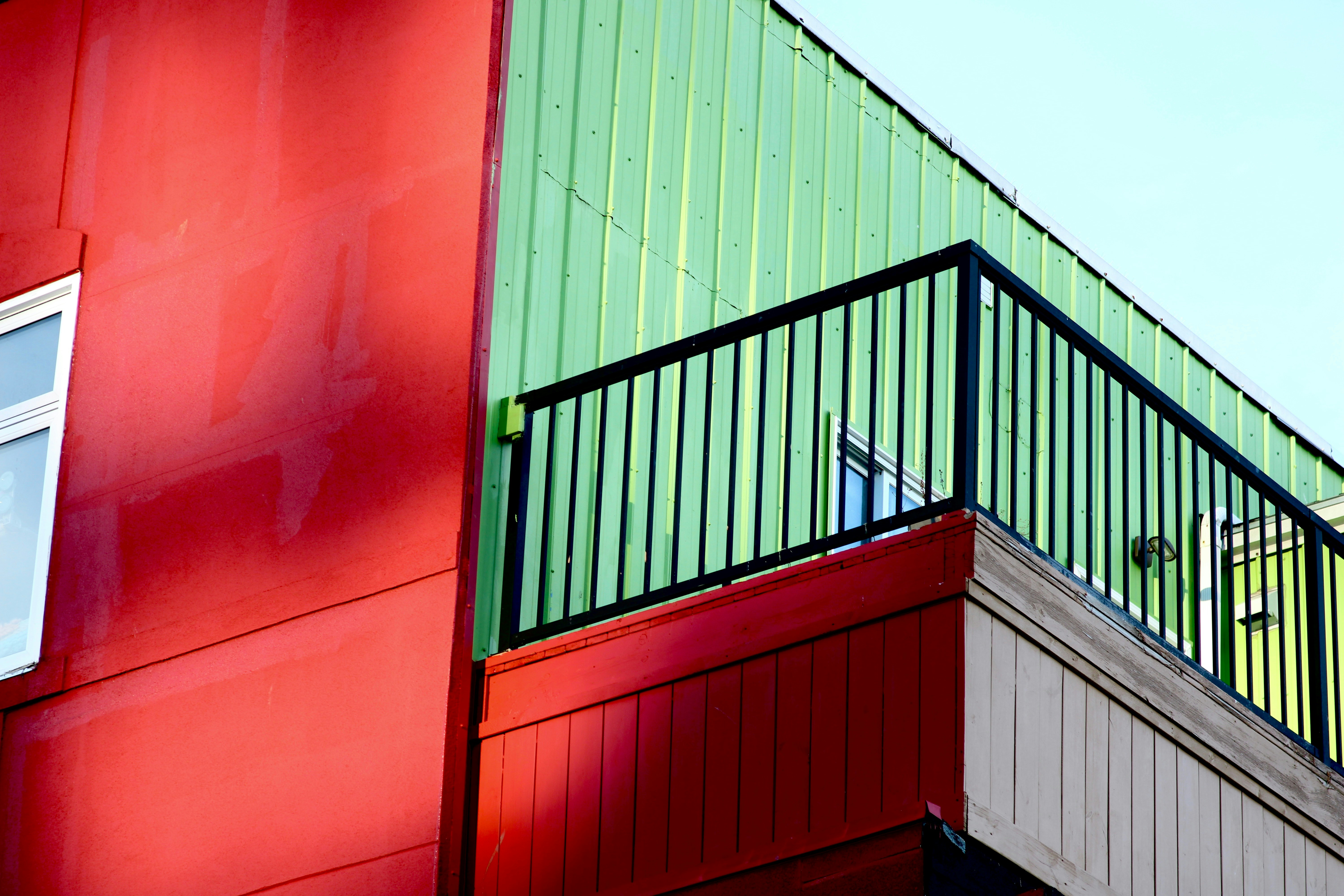 Corner of Color: Red Facade Meets Green Balcony