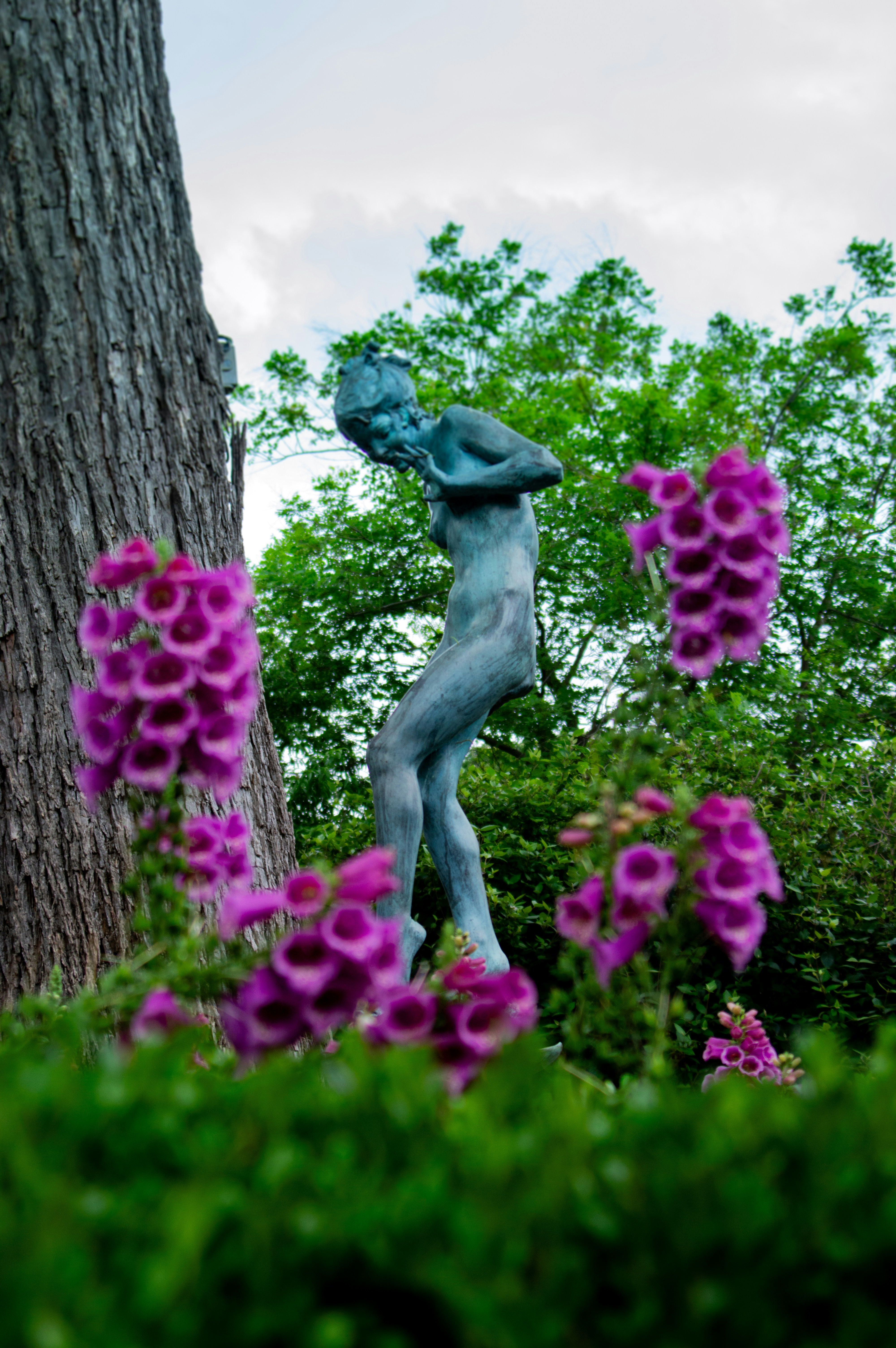 Bronze Nude Amid Magenta Foxgloves in a Quiet Garden