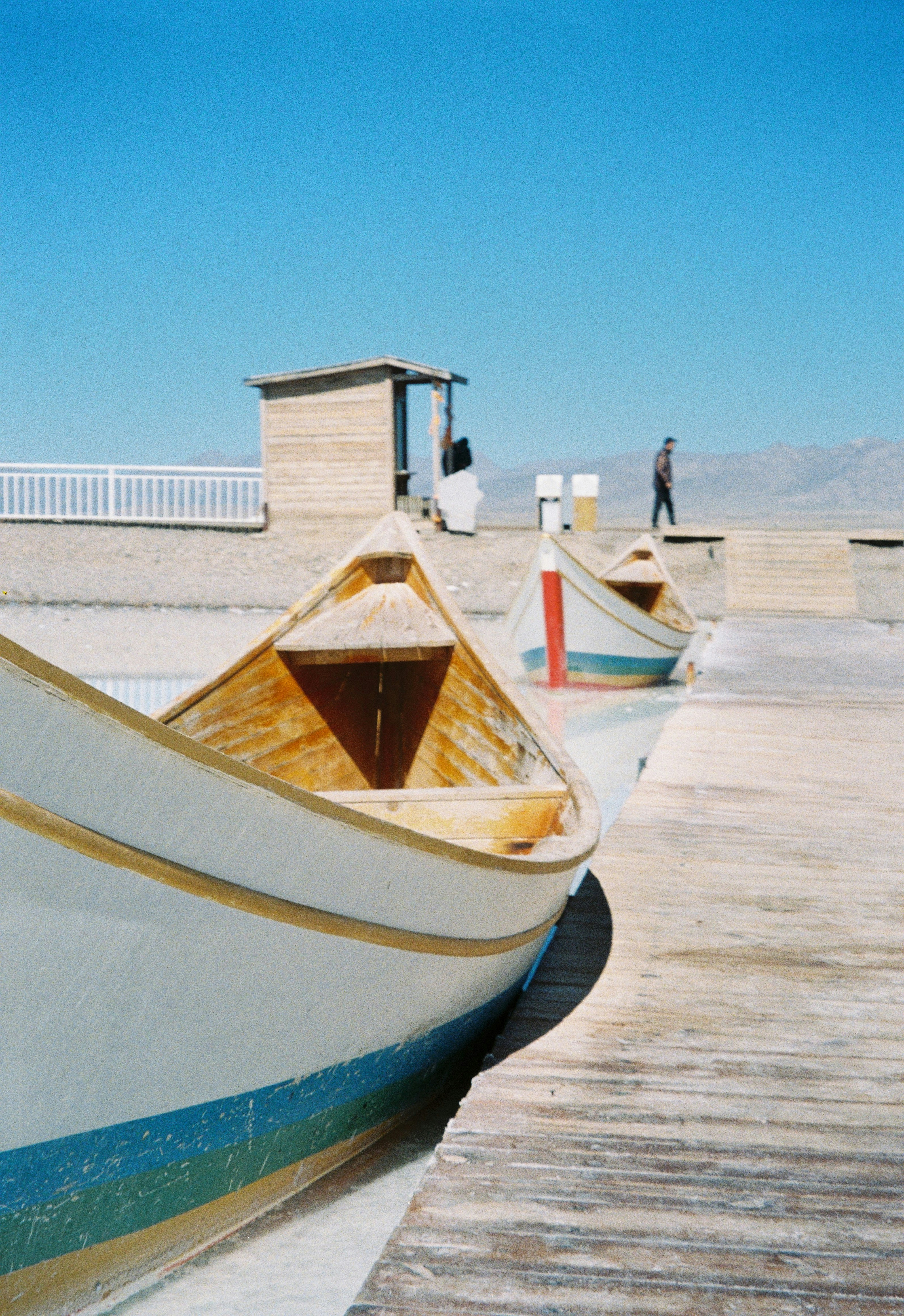 Sunlit Hulls Along the Curved Pier: A Quiet Maritime Moment