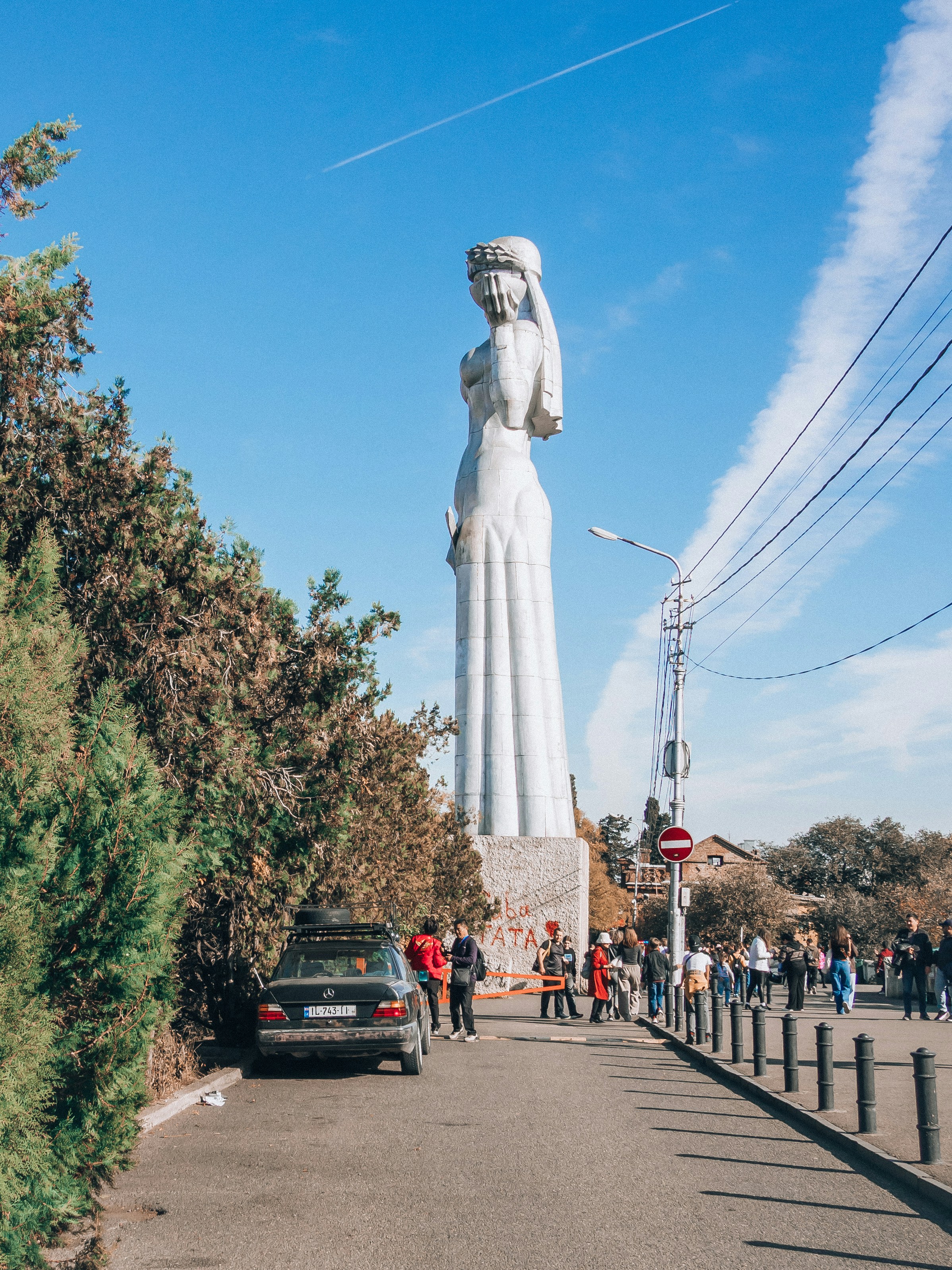 A group of people standing around a large white statue