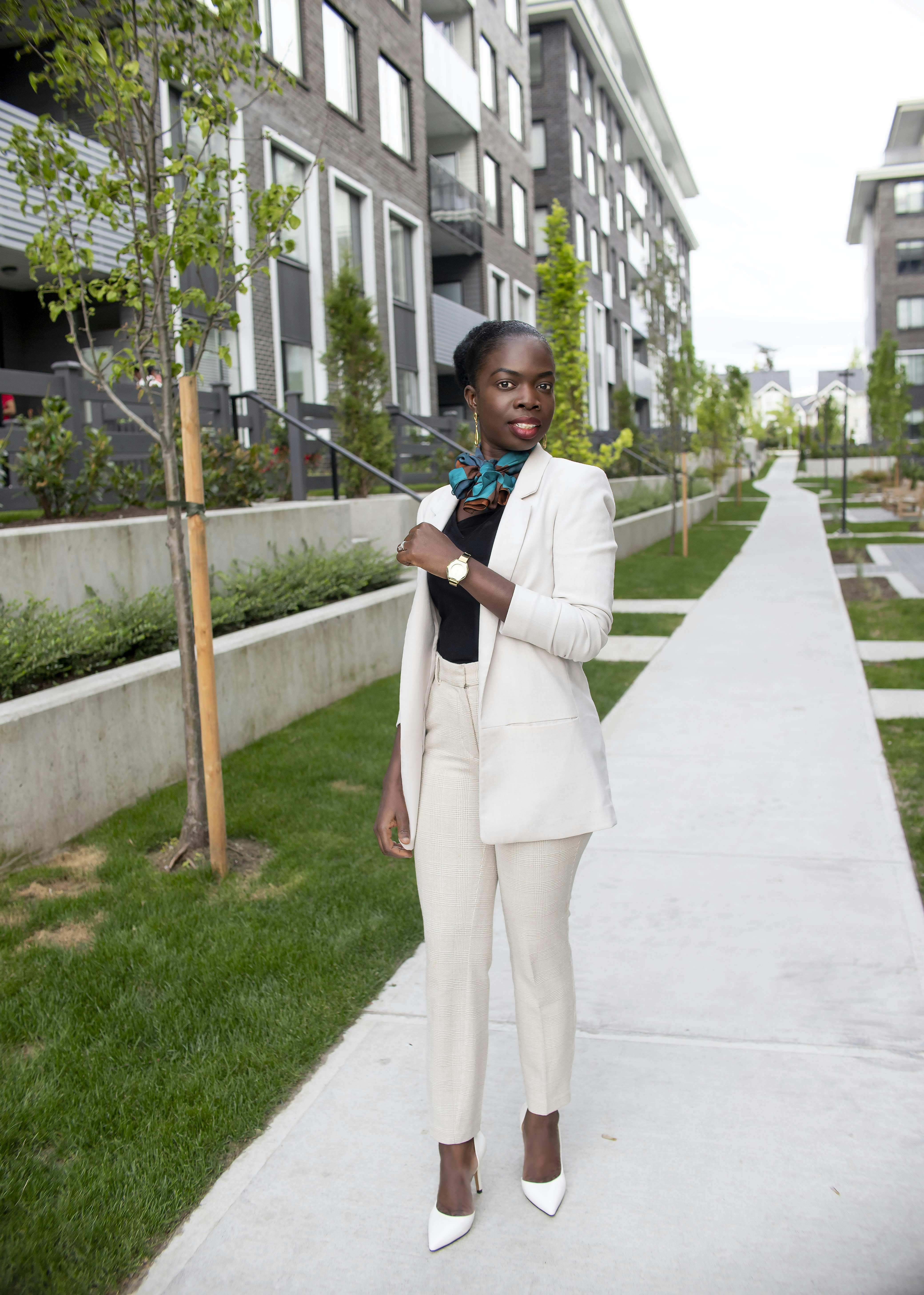 A woman in a white suit standing on a sidewalk photo – Free Official ...