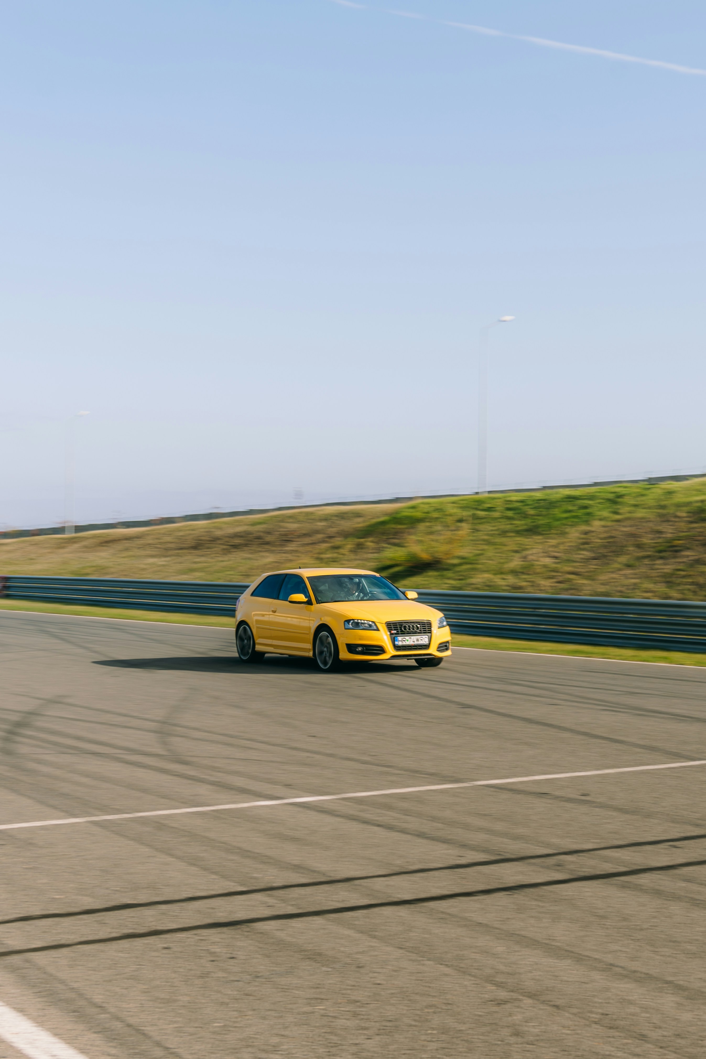A yellow car driving down a race track photo – Free Car Image on Unsplash