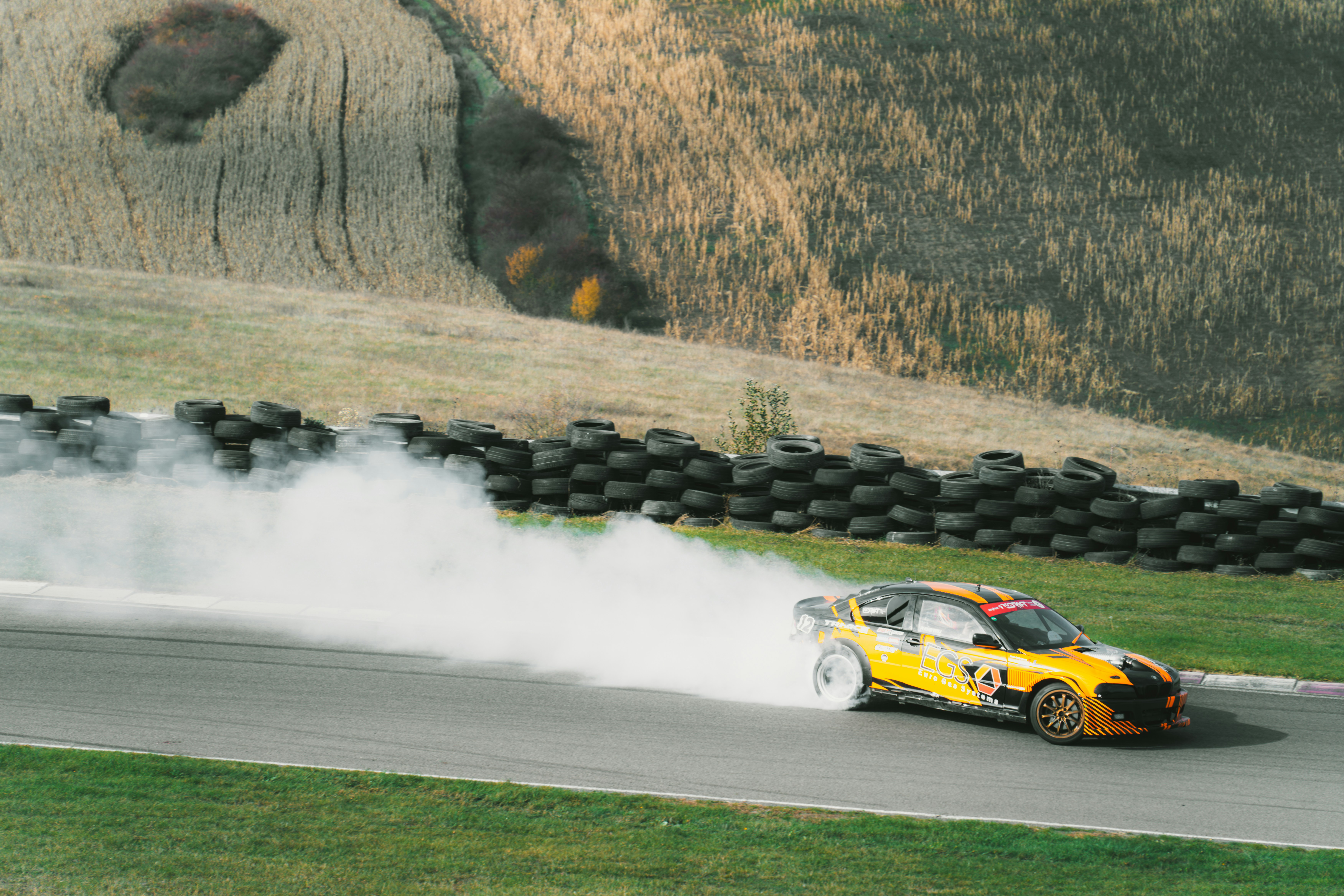 Yellow Drift Machine Conquering a Tire-Barrier Corner in Smoke