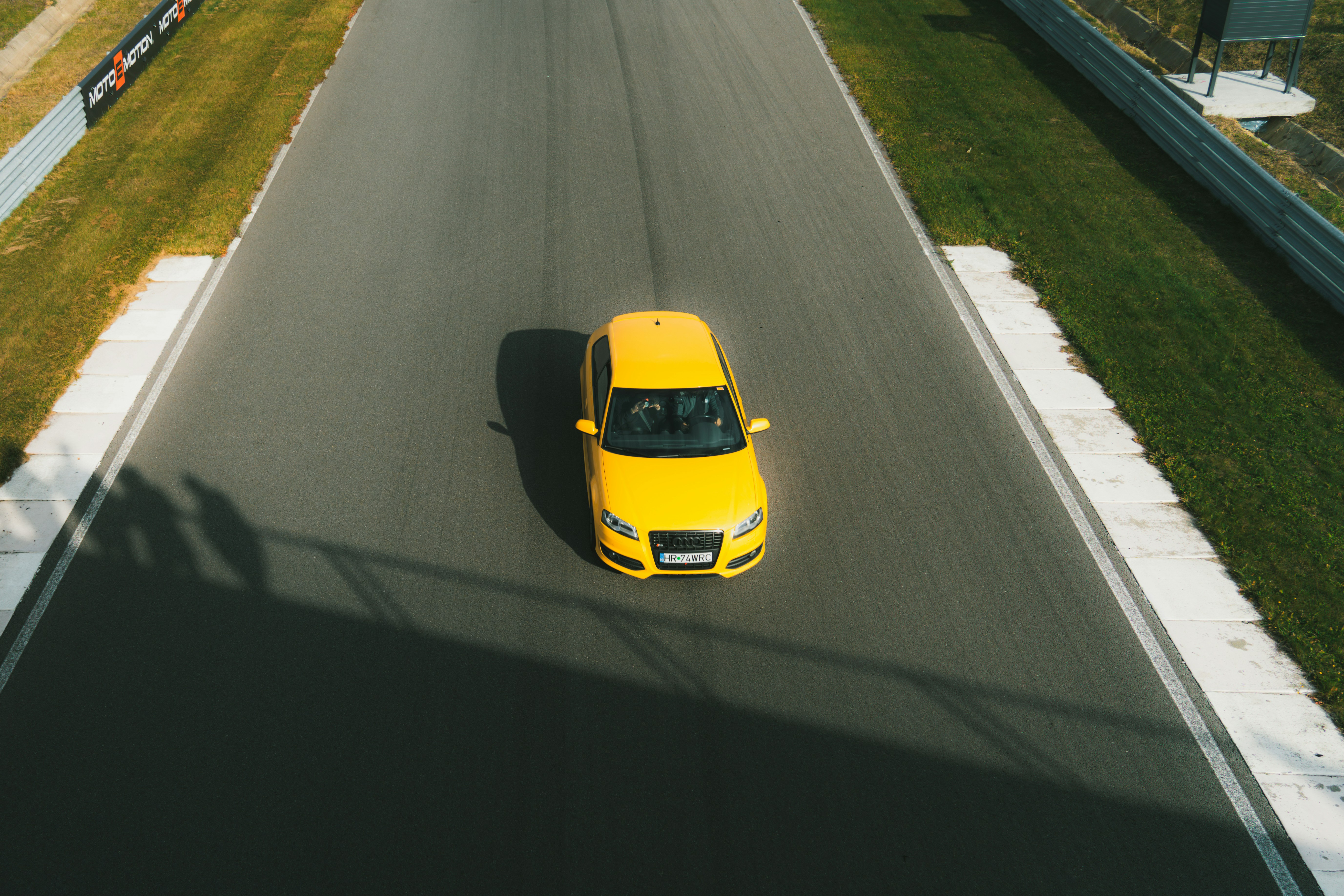 A yellow sports car driving down a race track photo – Free Car Image on ...
