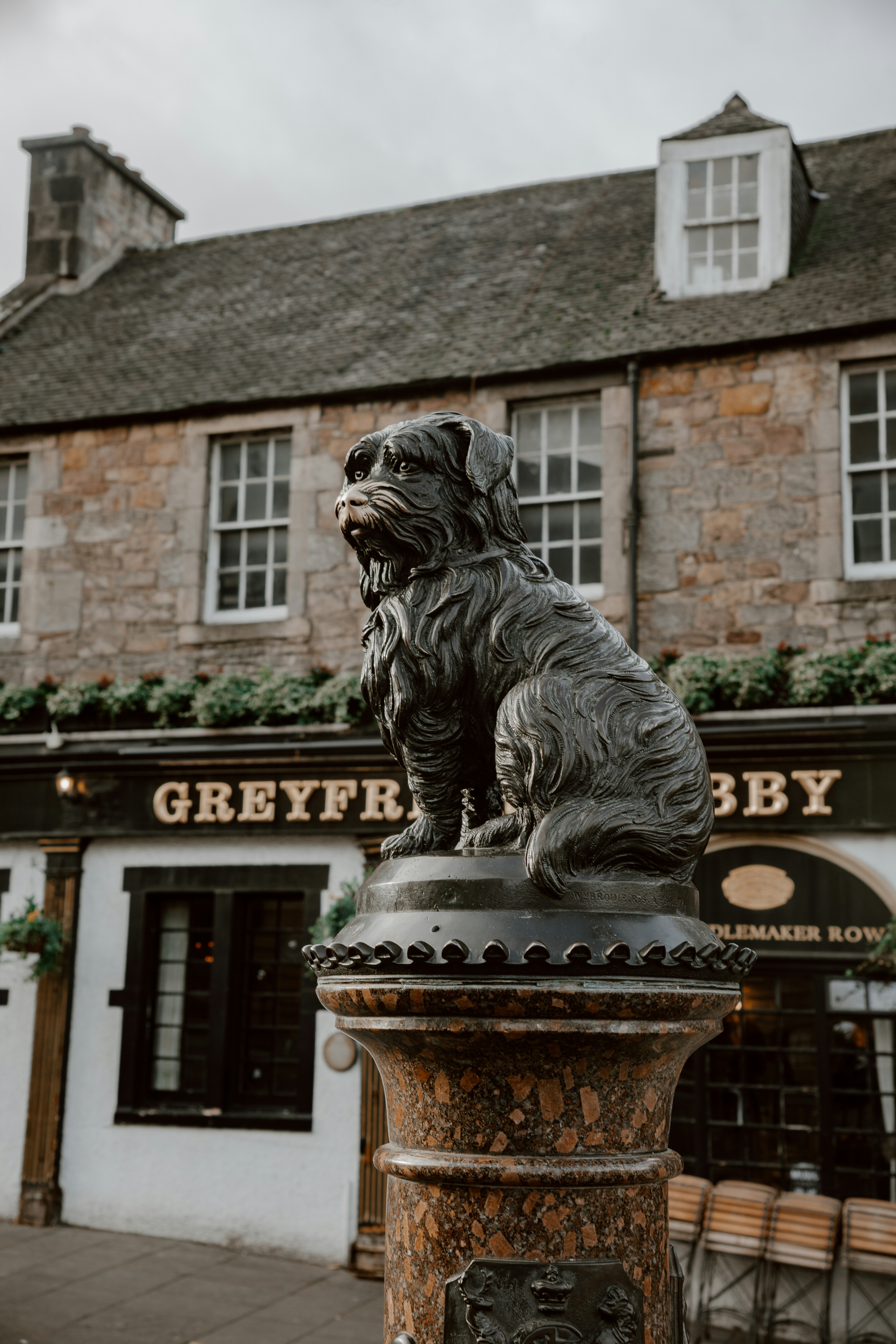 A statue of a dog on a pedestal in front of a building photo – Free Greyfriars bobby statue ...