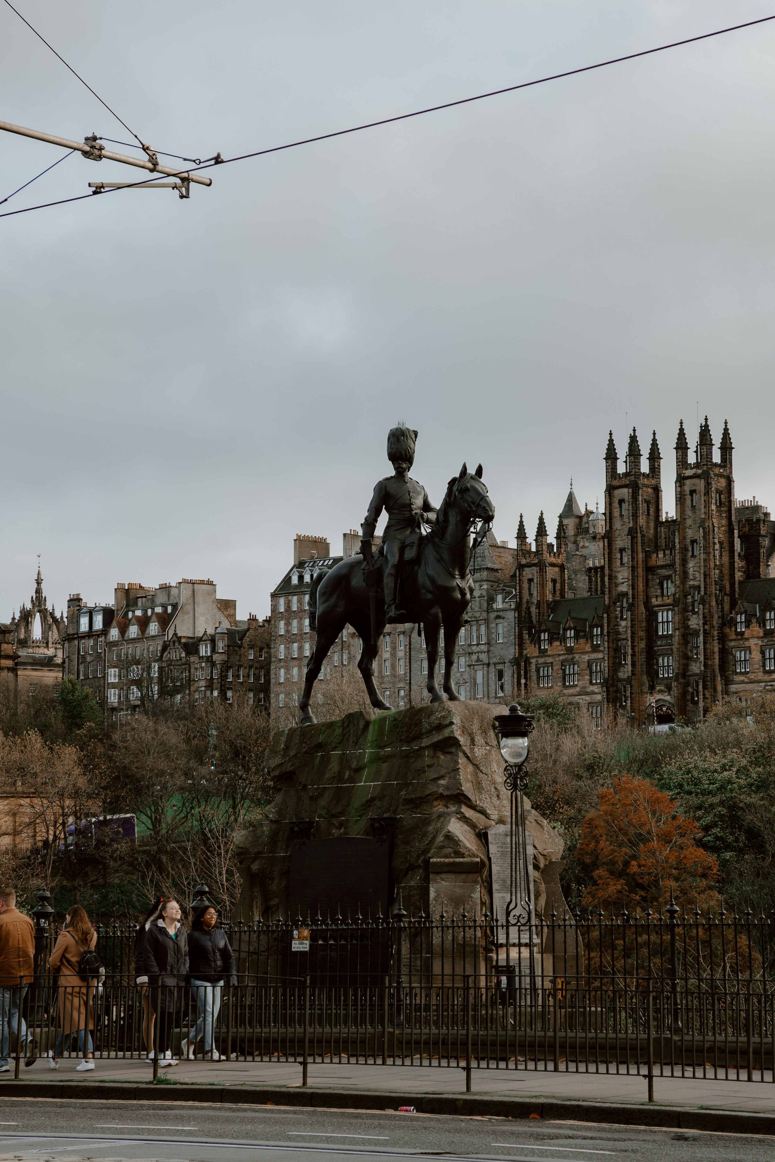 Equestrian Monument Framed by Gothic Towers and Tram Lines