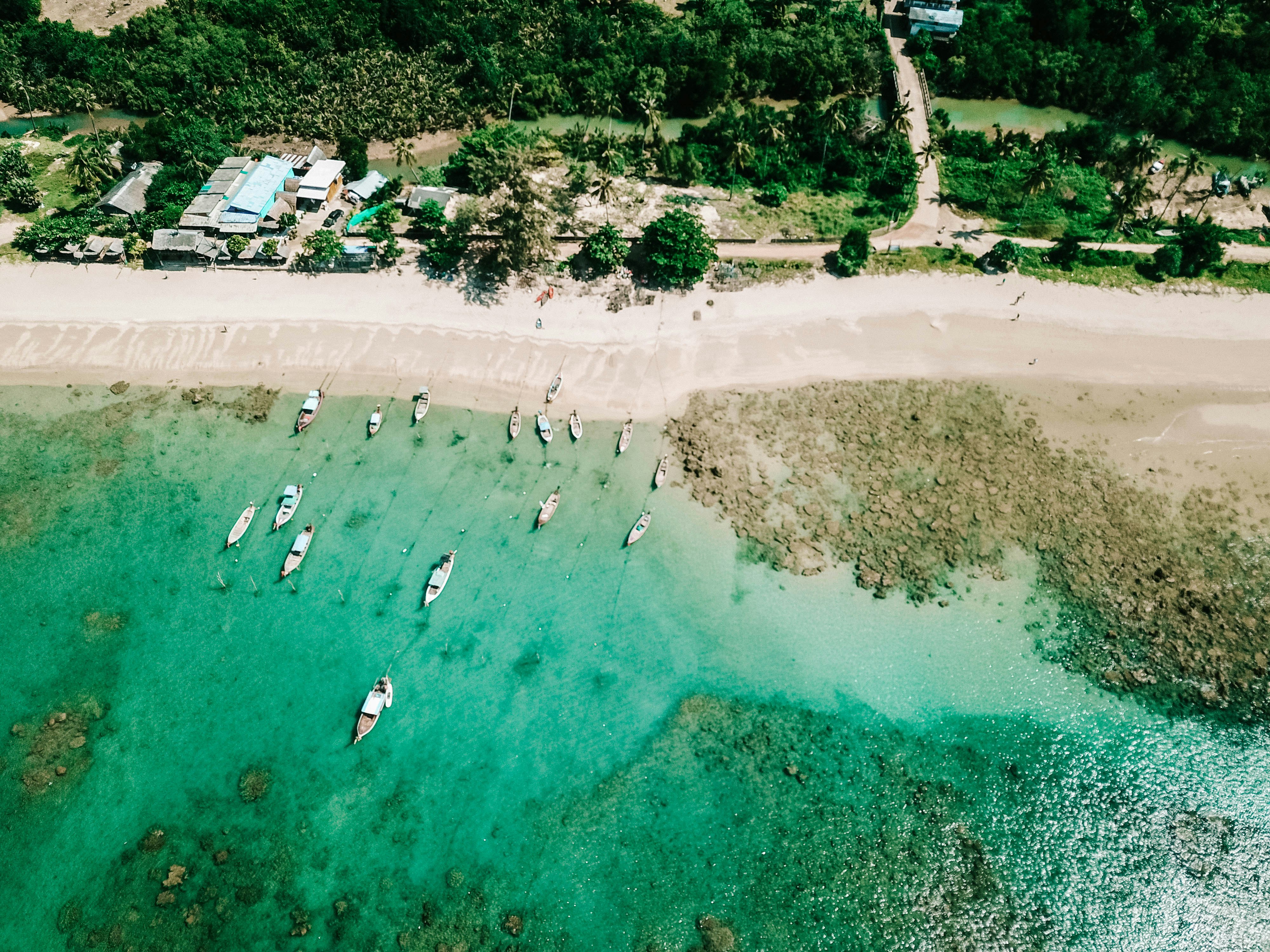 Emerald Coastline: A Fleet Lined Up Along Turquoise Waters