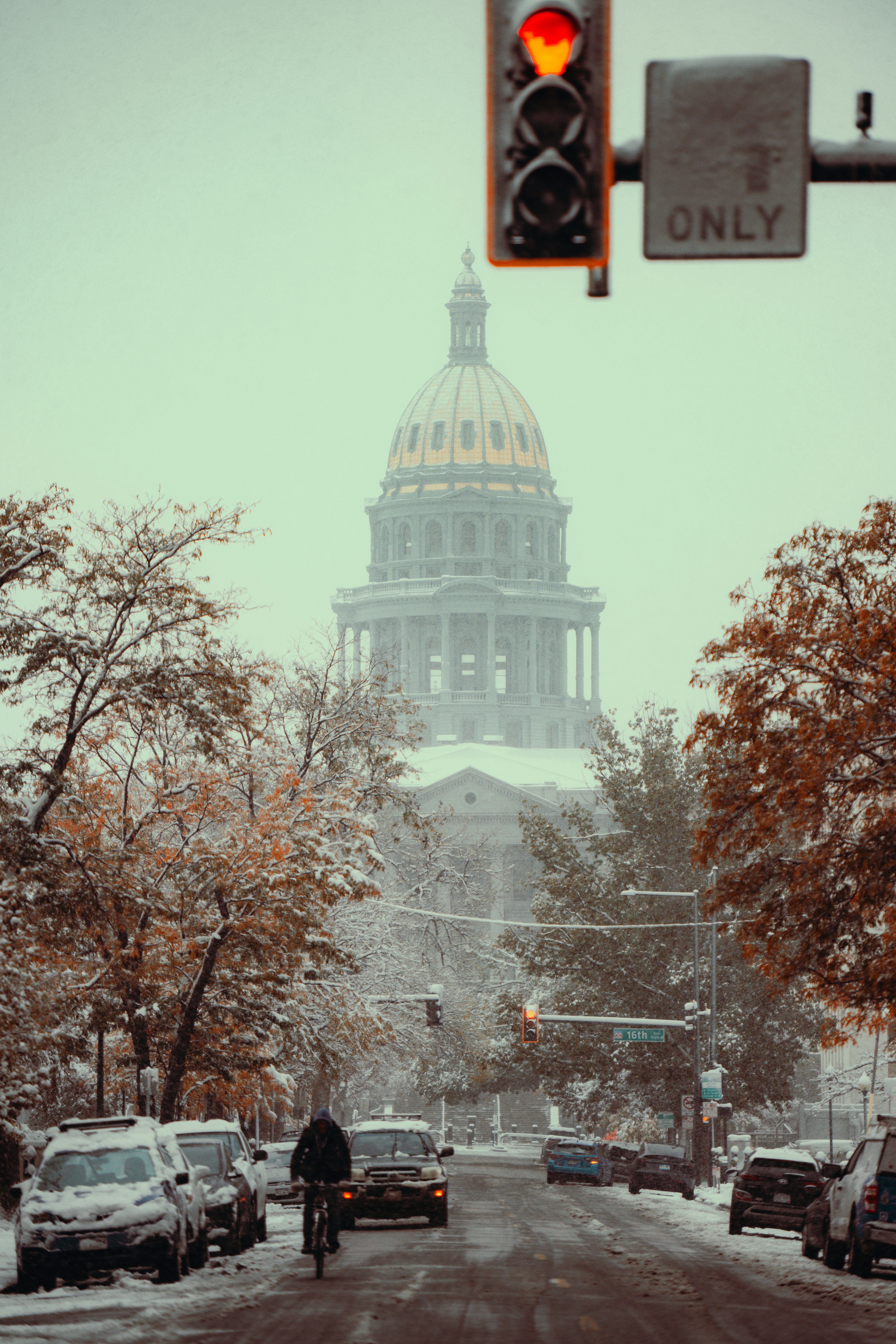 A traffic light on a snowy street with a dome in the background photo ...