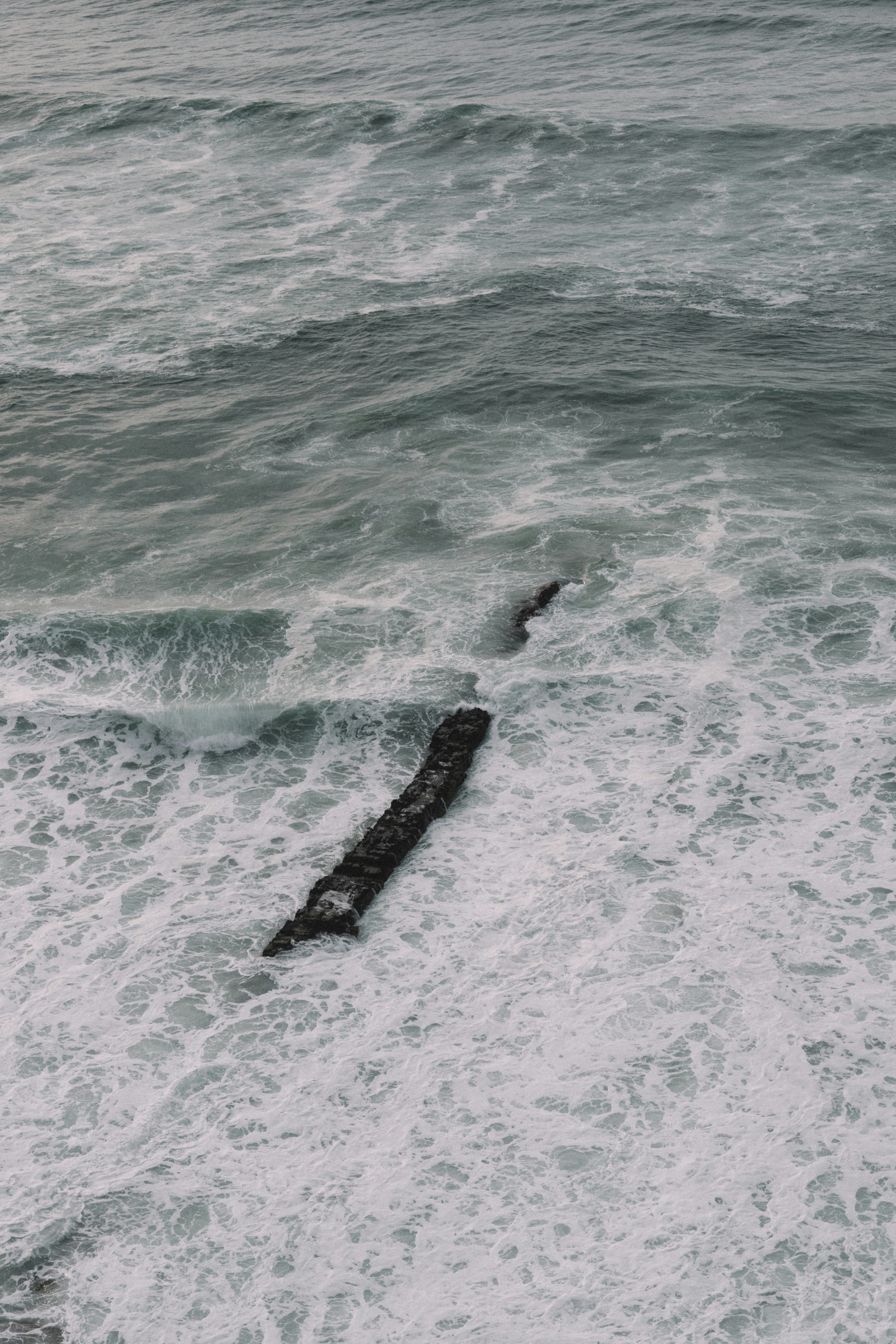 Dark Jetty Carves a Foam-Flecked Path Through the Sea
