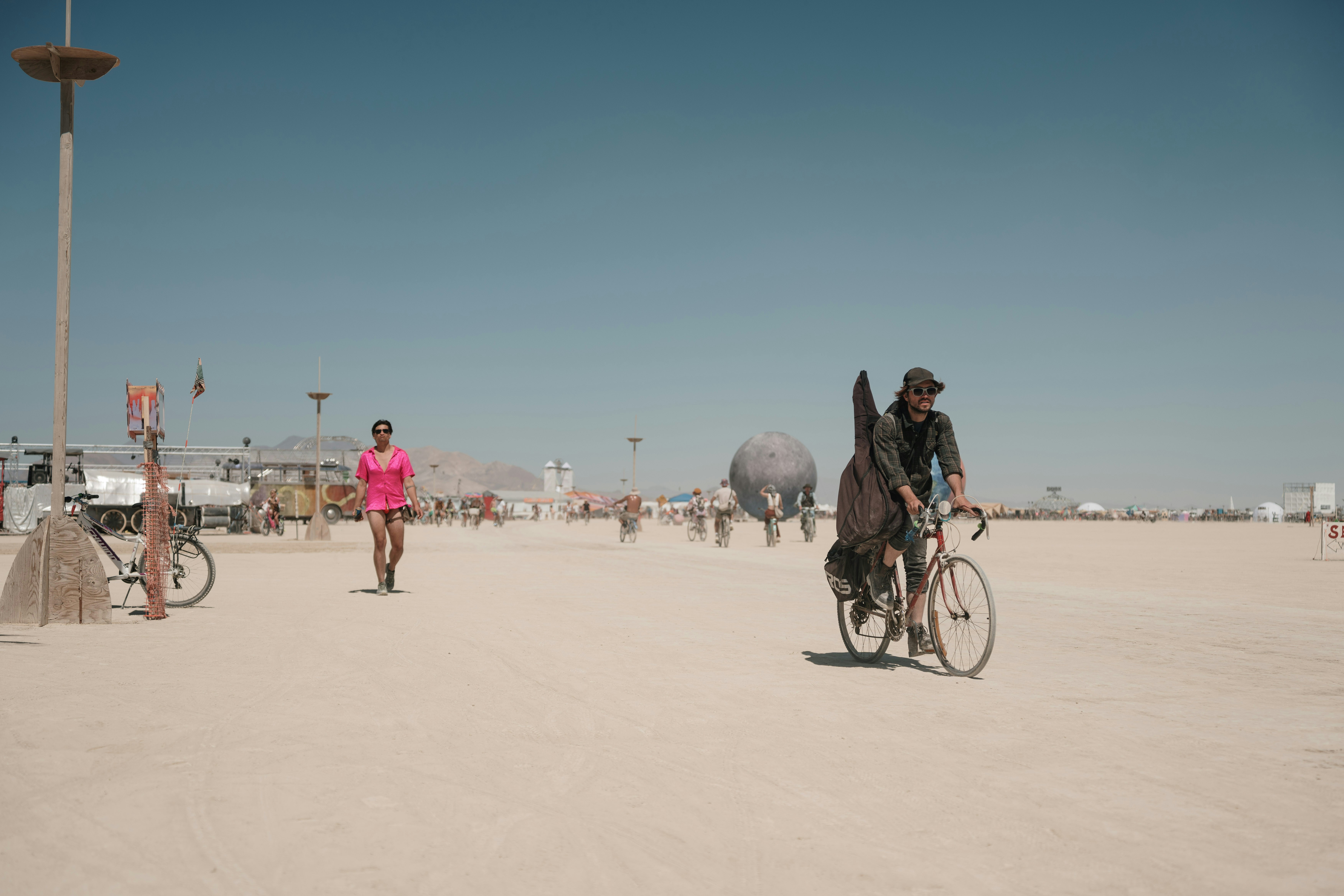 Burning Man Festival - in Nevada Black Rock City Couple on the background with Art Car in a Desert. Photographer Anton Mislawsky