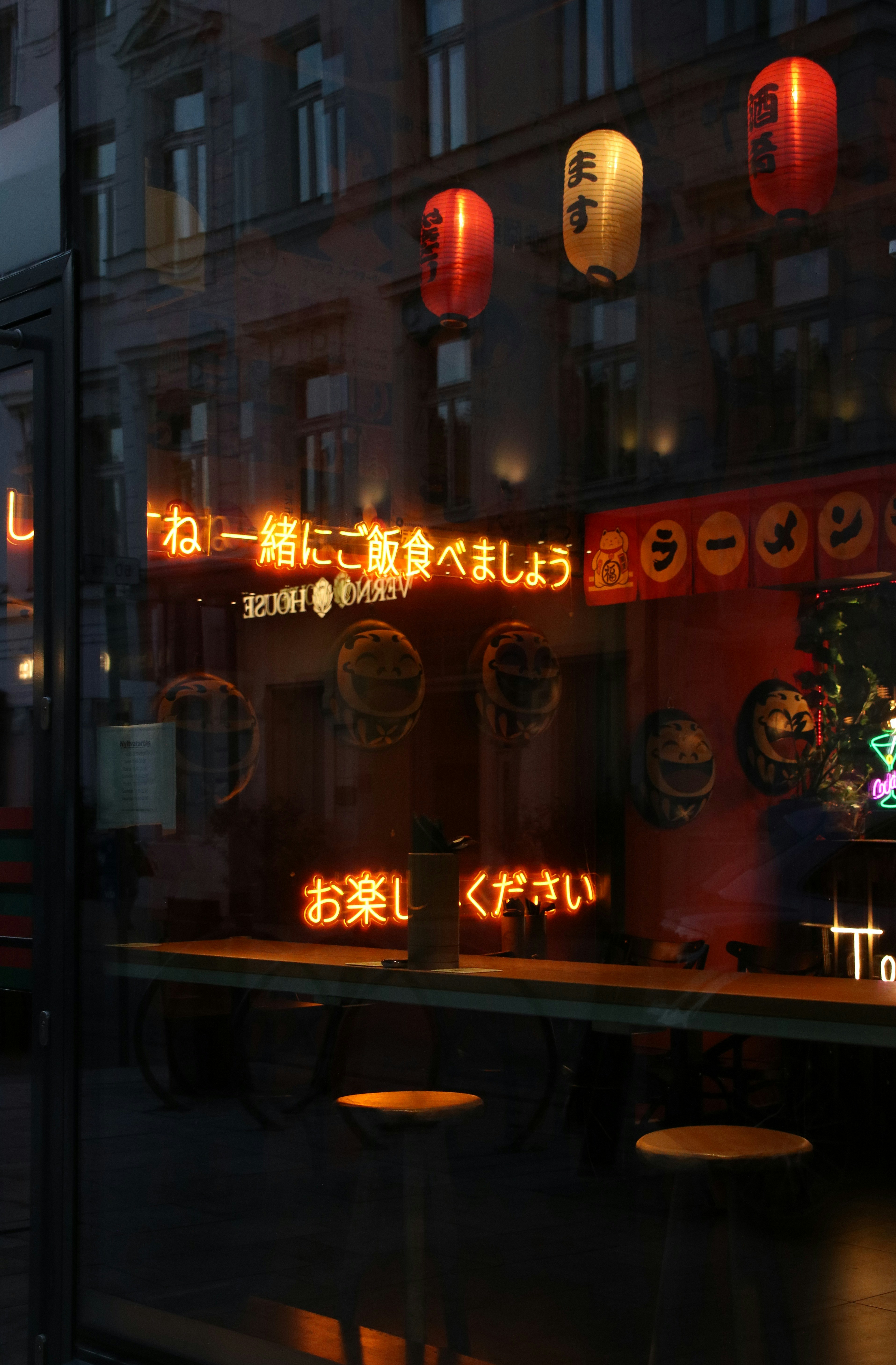 Neon Lantern Reflections: Night-market Glow Through a Glass Window