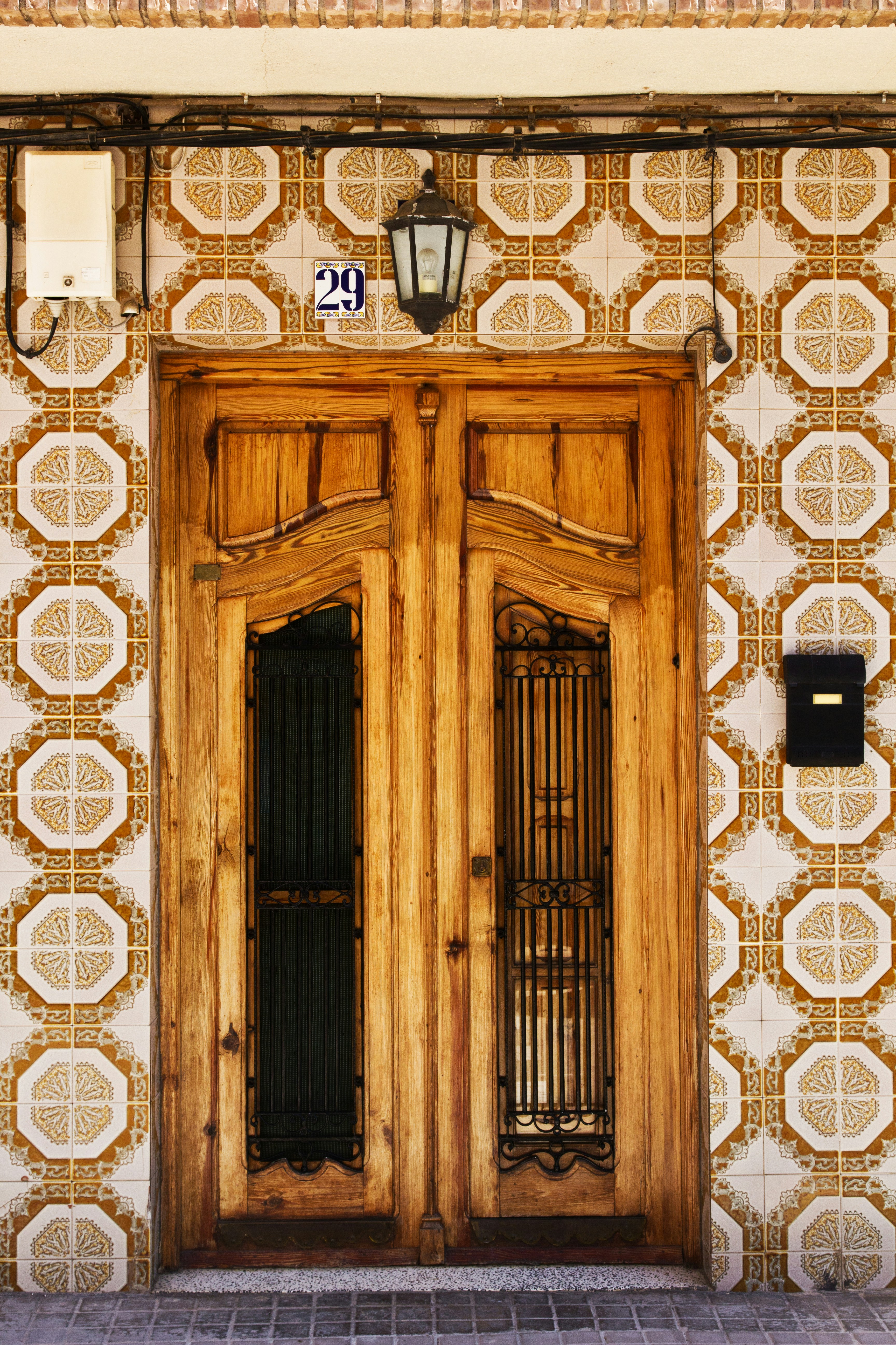 Symmetry in Walnut: A Vintage Door Framed by Geometric Tilework