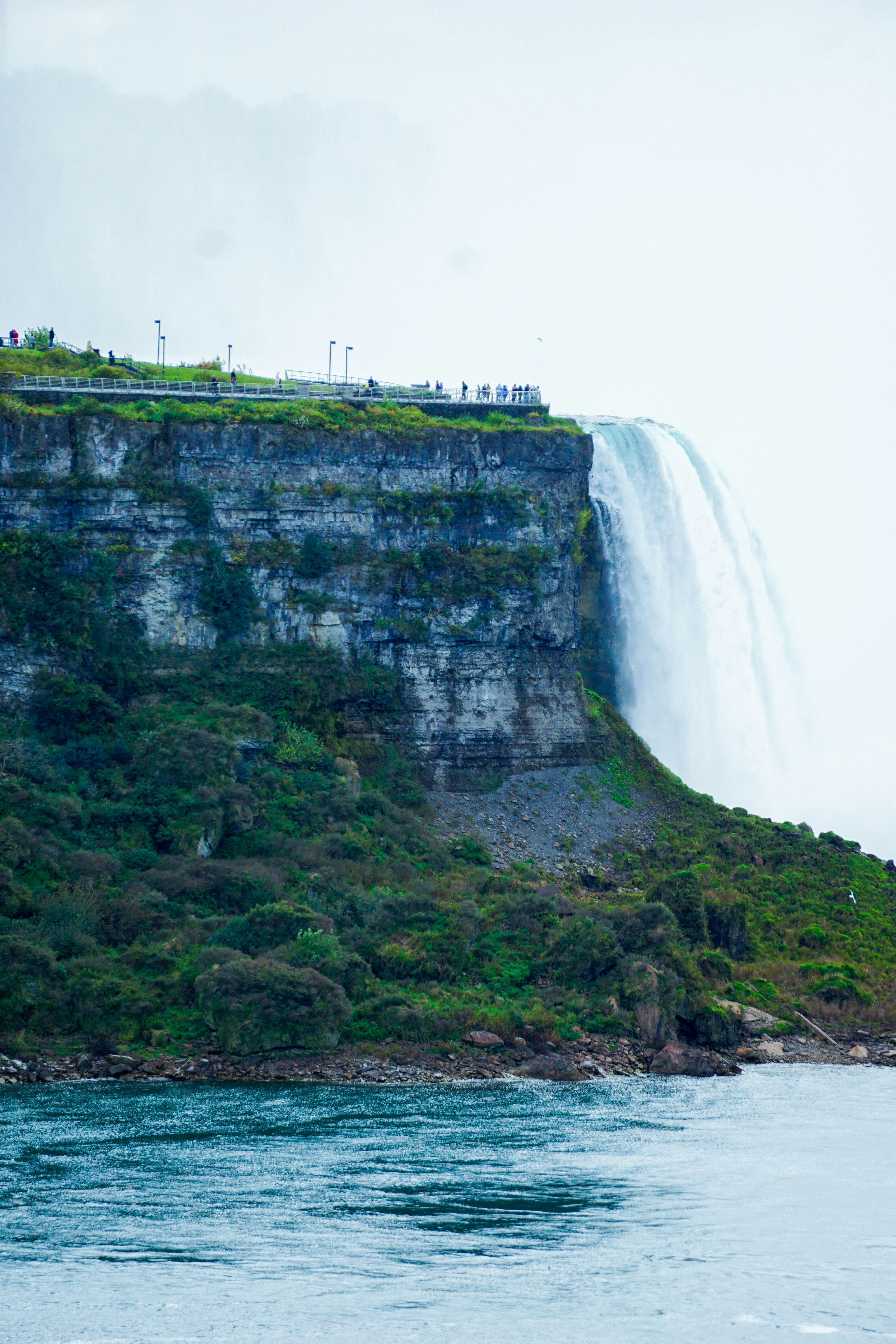 Cliffside Cascade Overlook: Visitors Gaze at a Looming Plunge