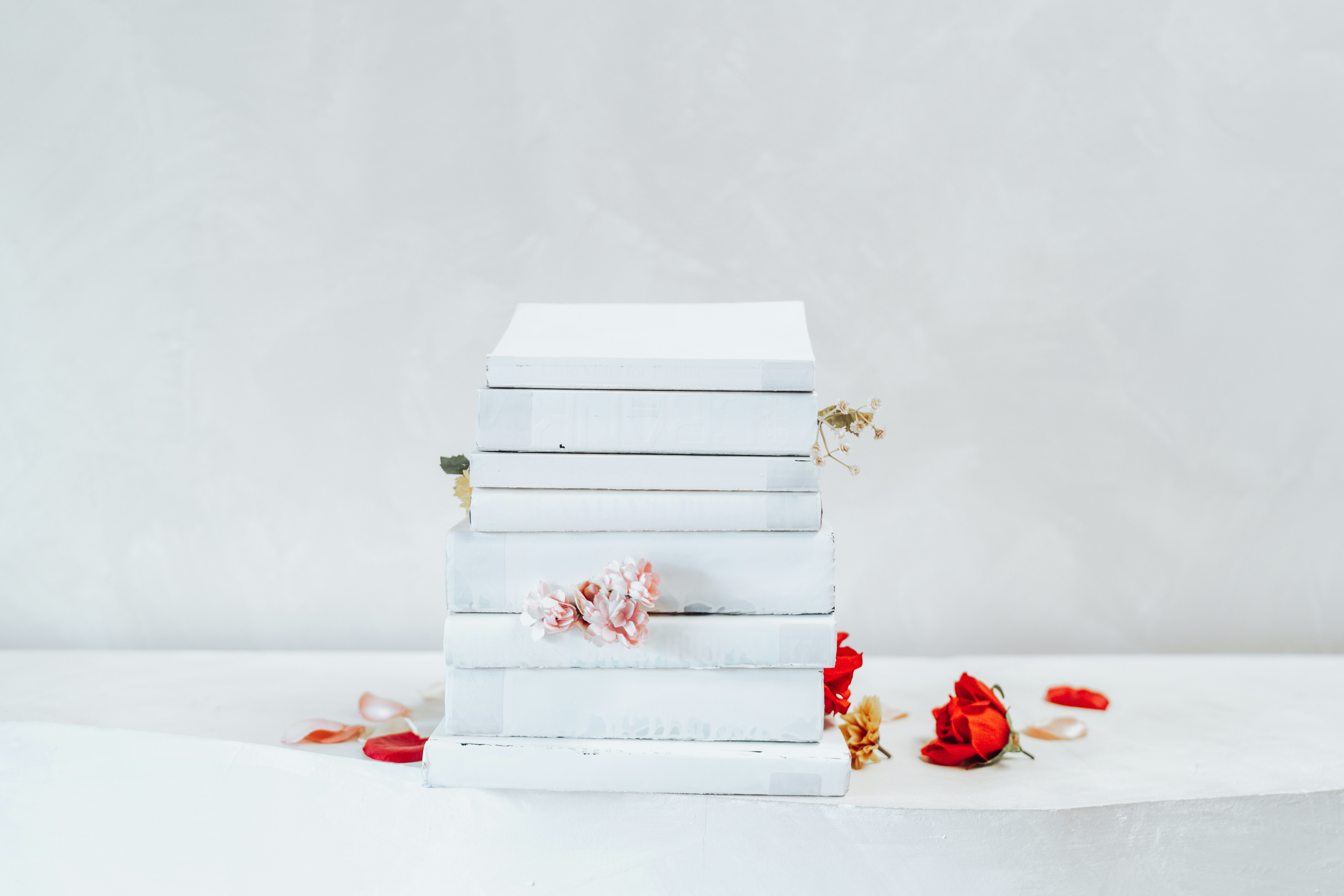A stack of books sitting on top of a white table photo – Free Rose ...