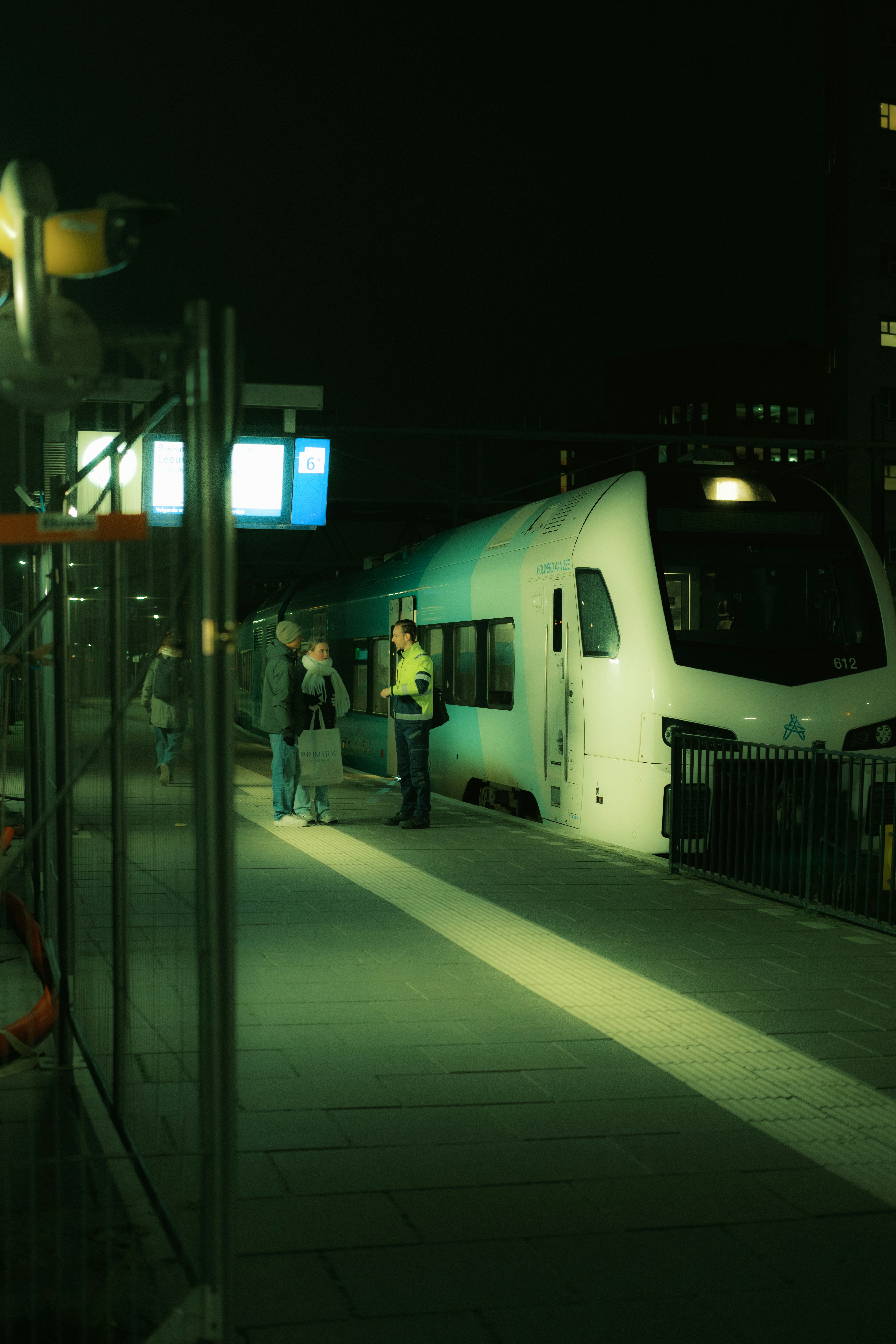 Nocturnal Platform Convergence: Passengers by a Sleek City Train