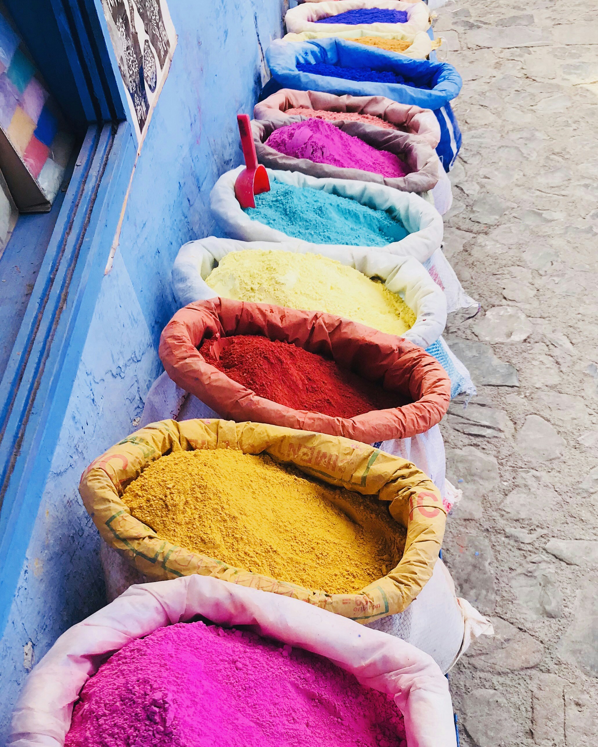 A row of bags filled with different colored powders photo – Free ...