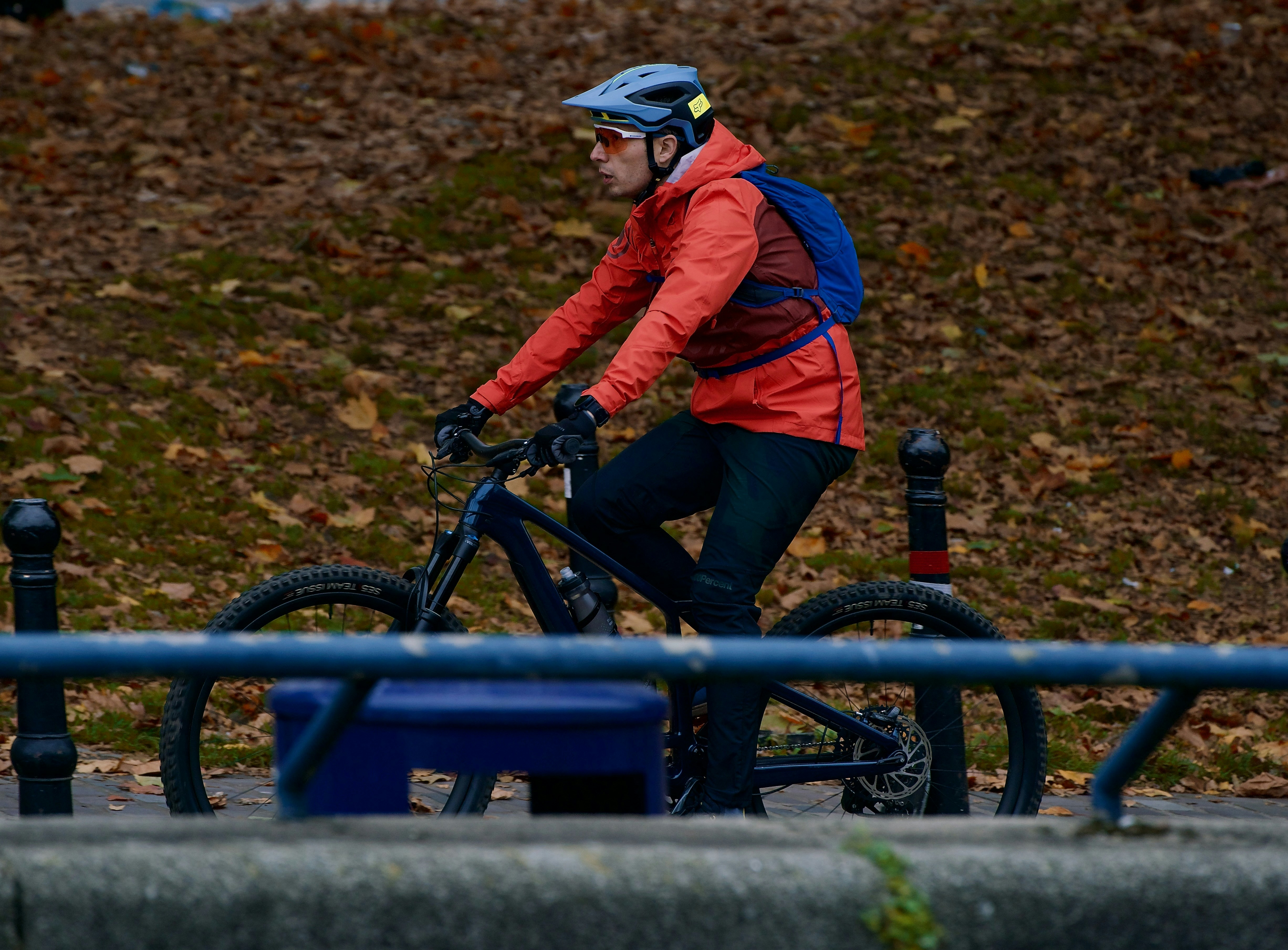 Momentum in Fall: A Red-Jacket Cyclist Navigates a Leaf-Littered Park