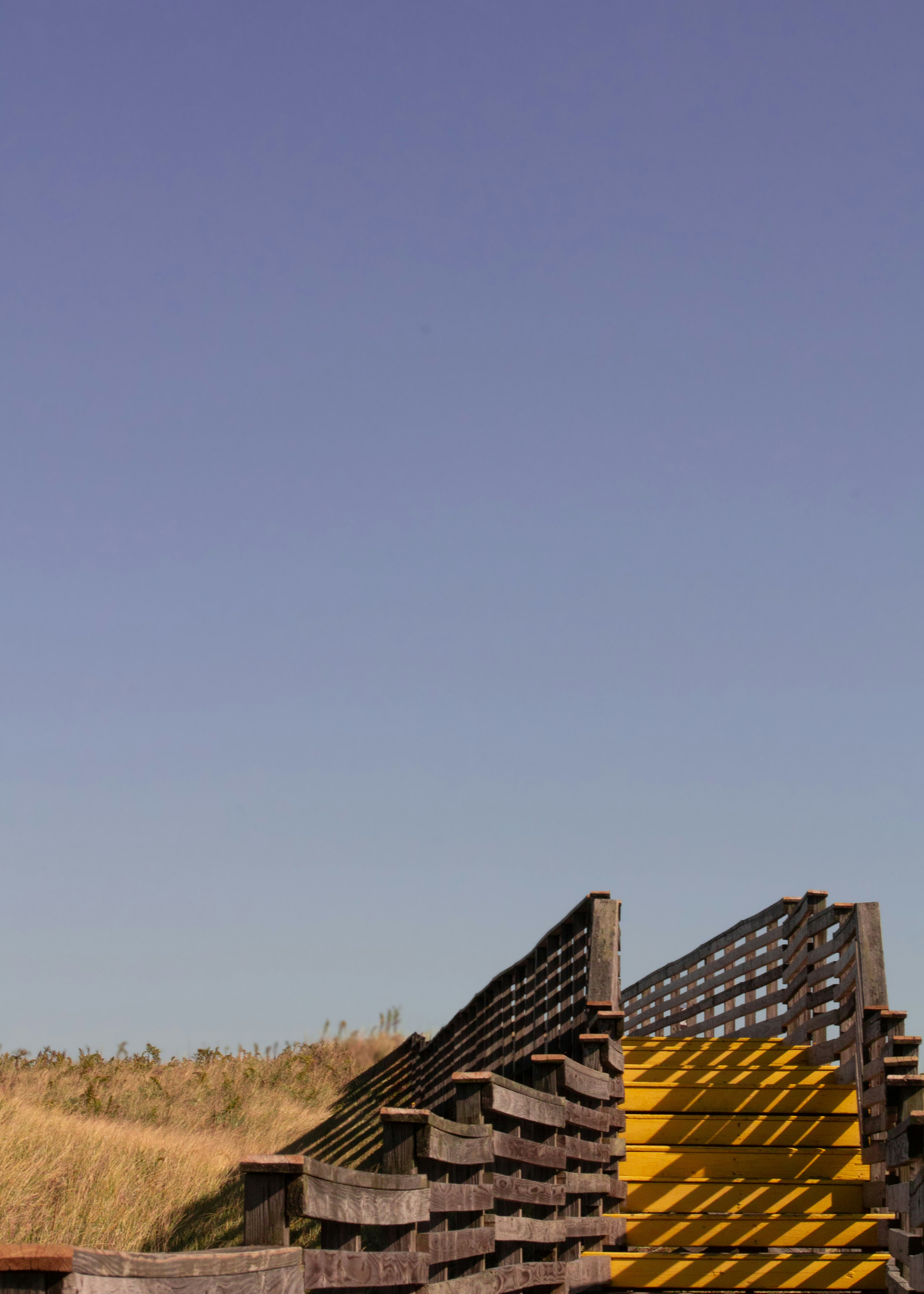 Yellow Steps, Blue Sky: A Coastal Stairway Reaching the Dunes
