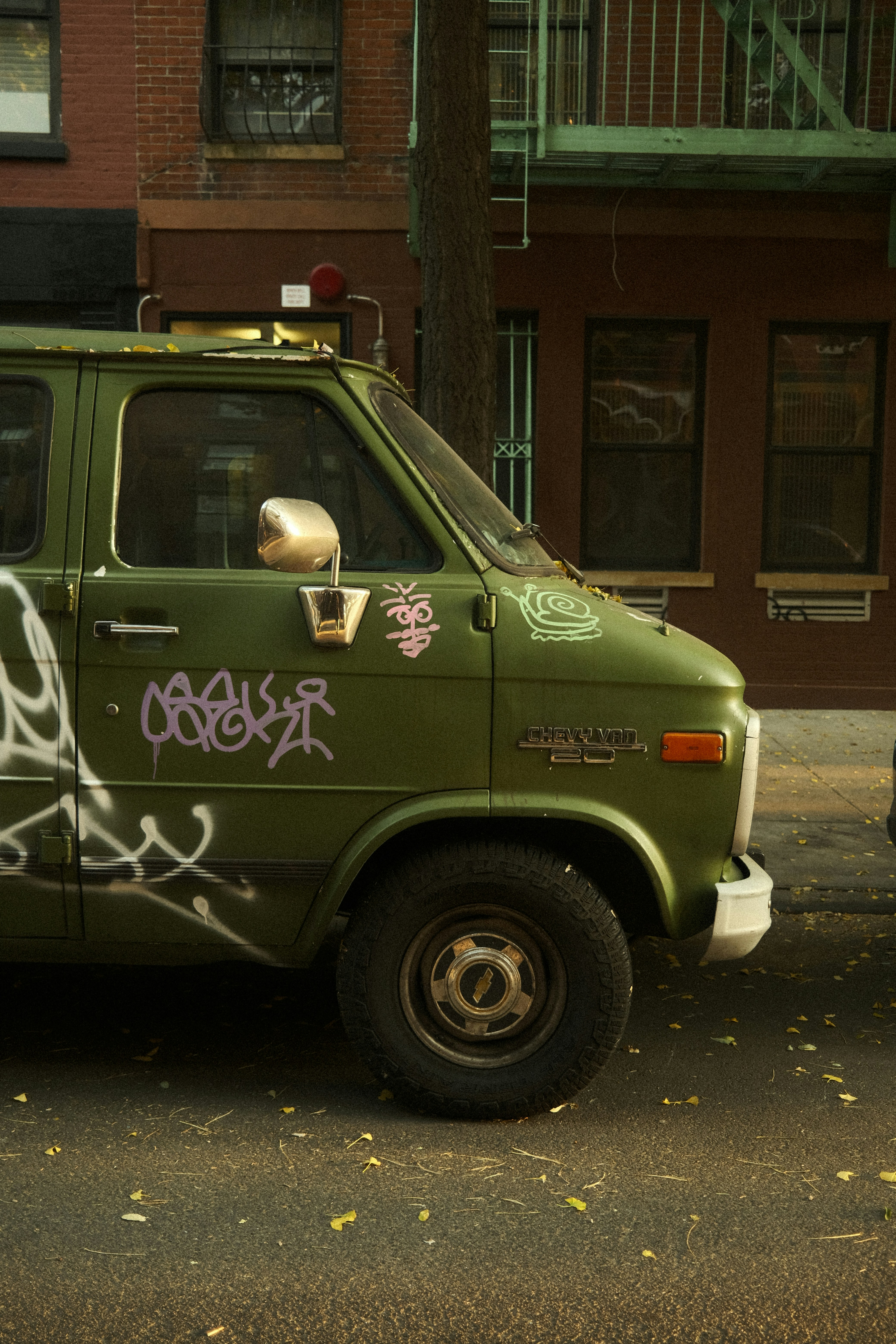 A green van with graffiti on the side of it