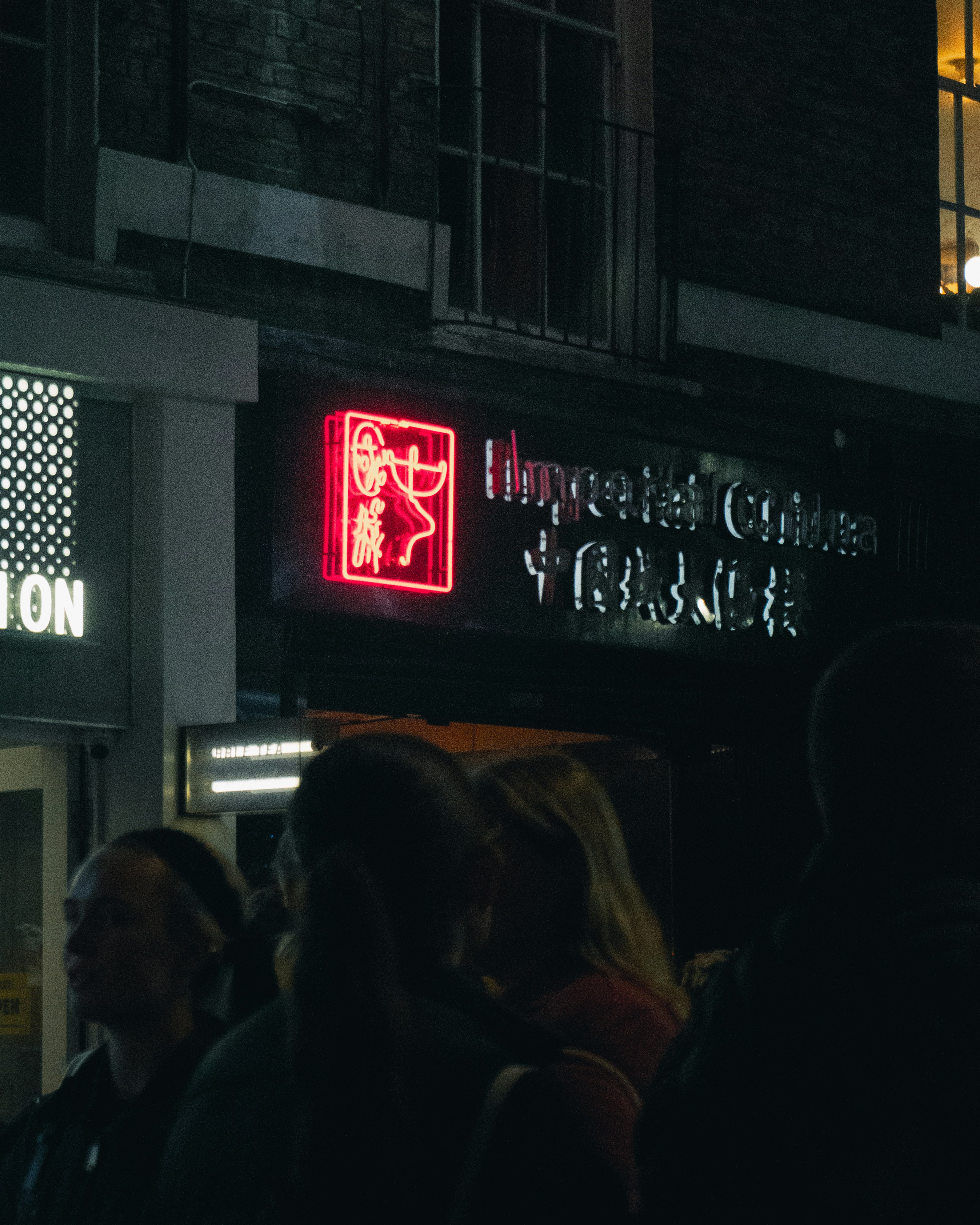 A group of people standing outside of a building at night