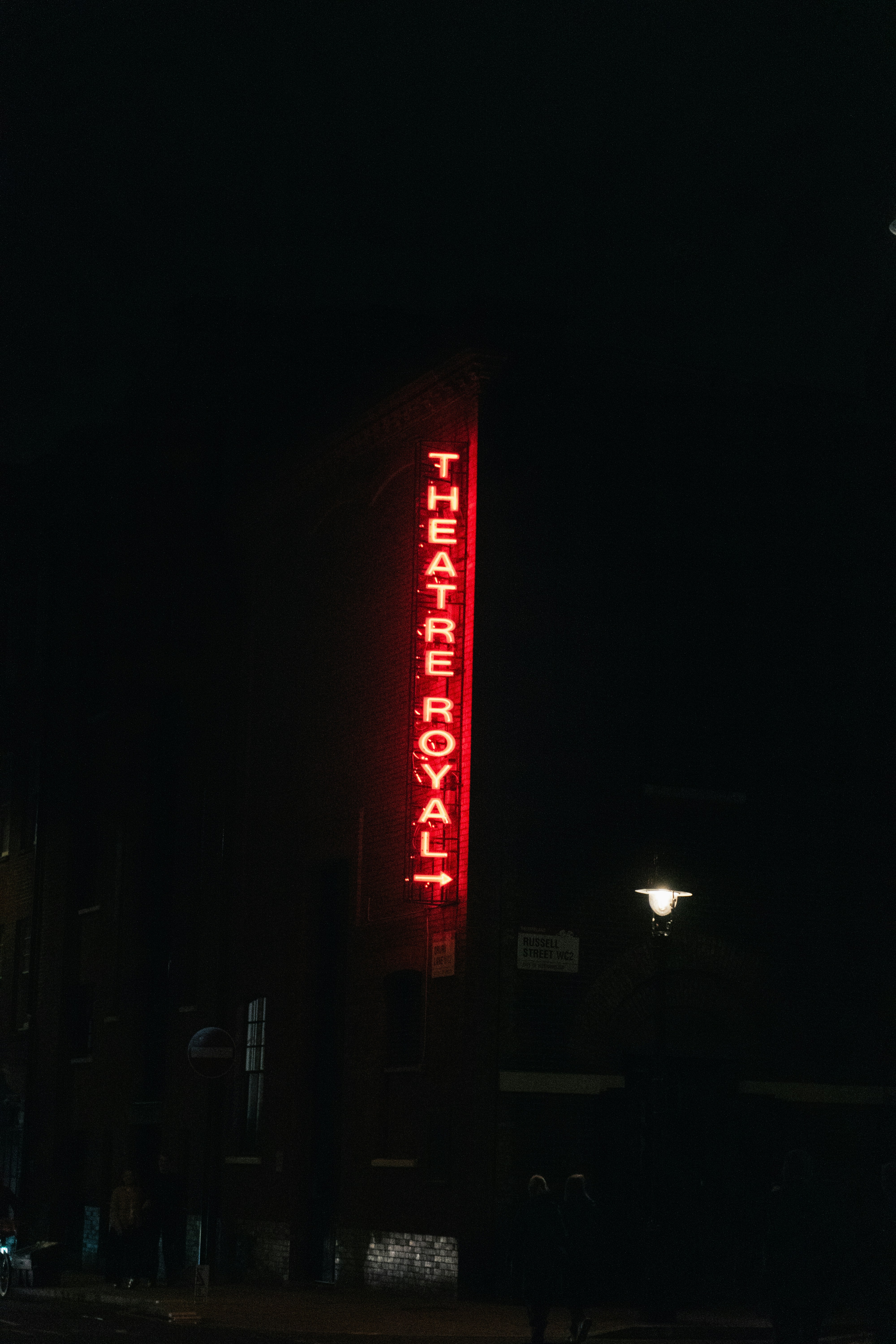 A red sign that is on the side of a building