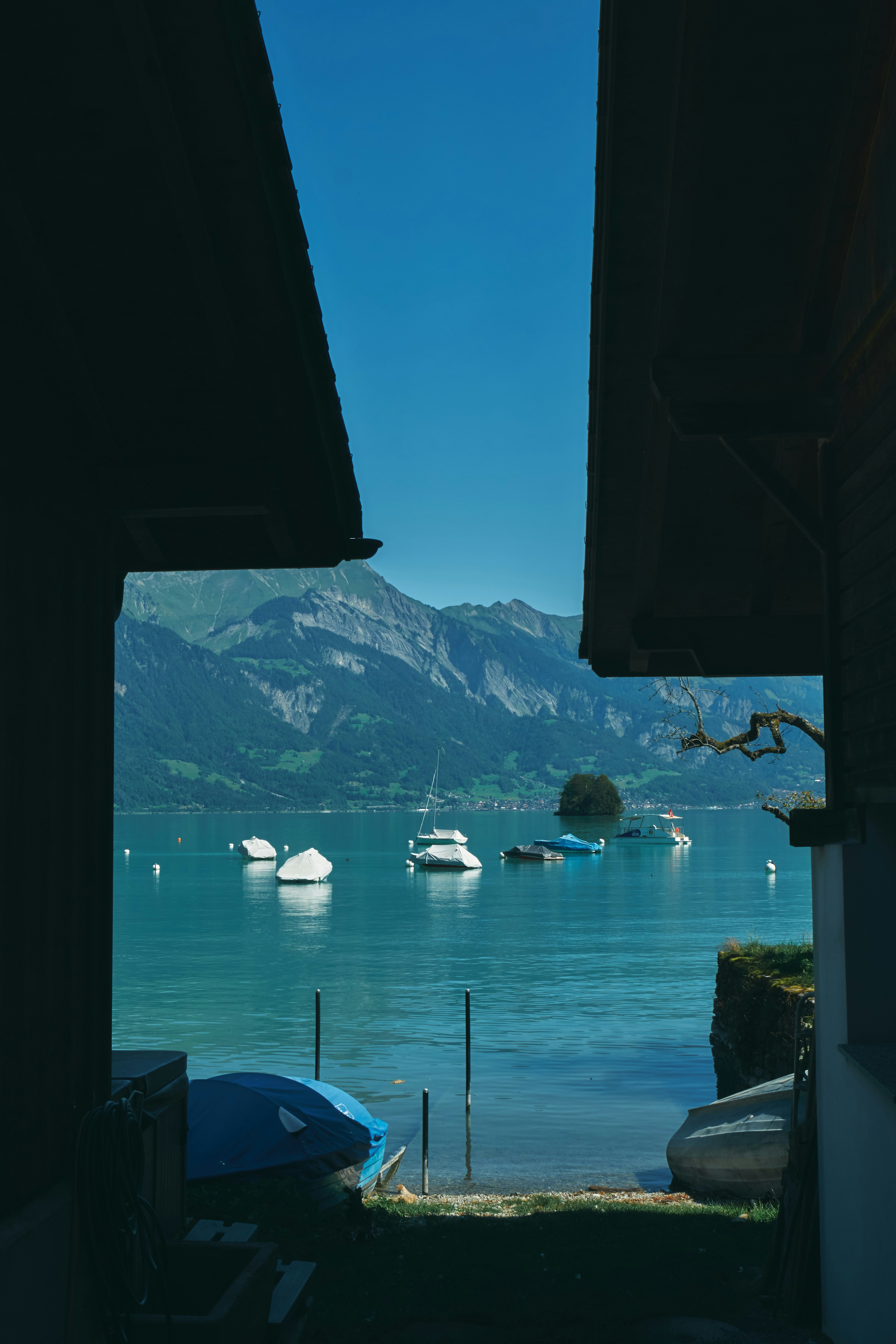 Between Shadowed Frames, Boats Rest on an Alpine Lake