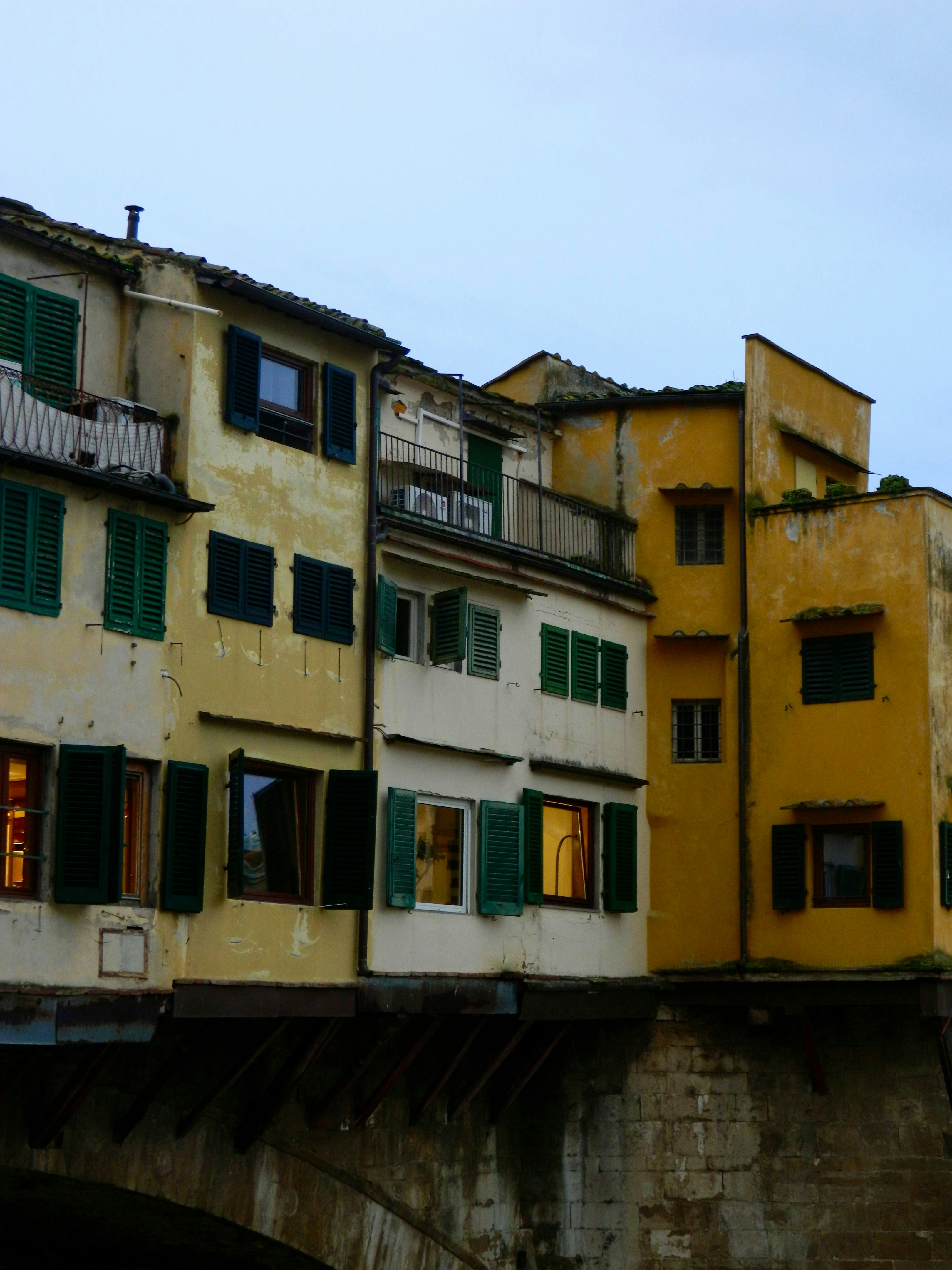 Riverside Facades: Yellow Walls and Green Shutters