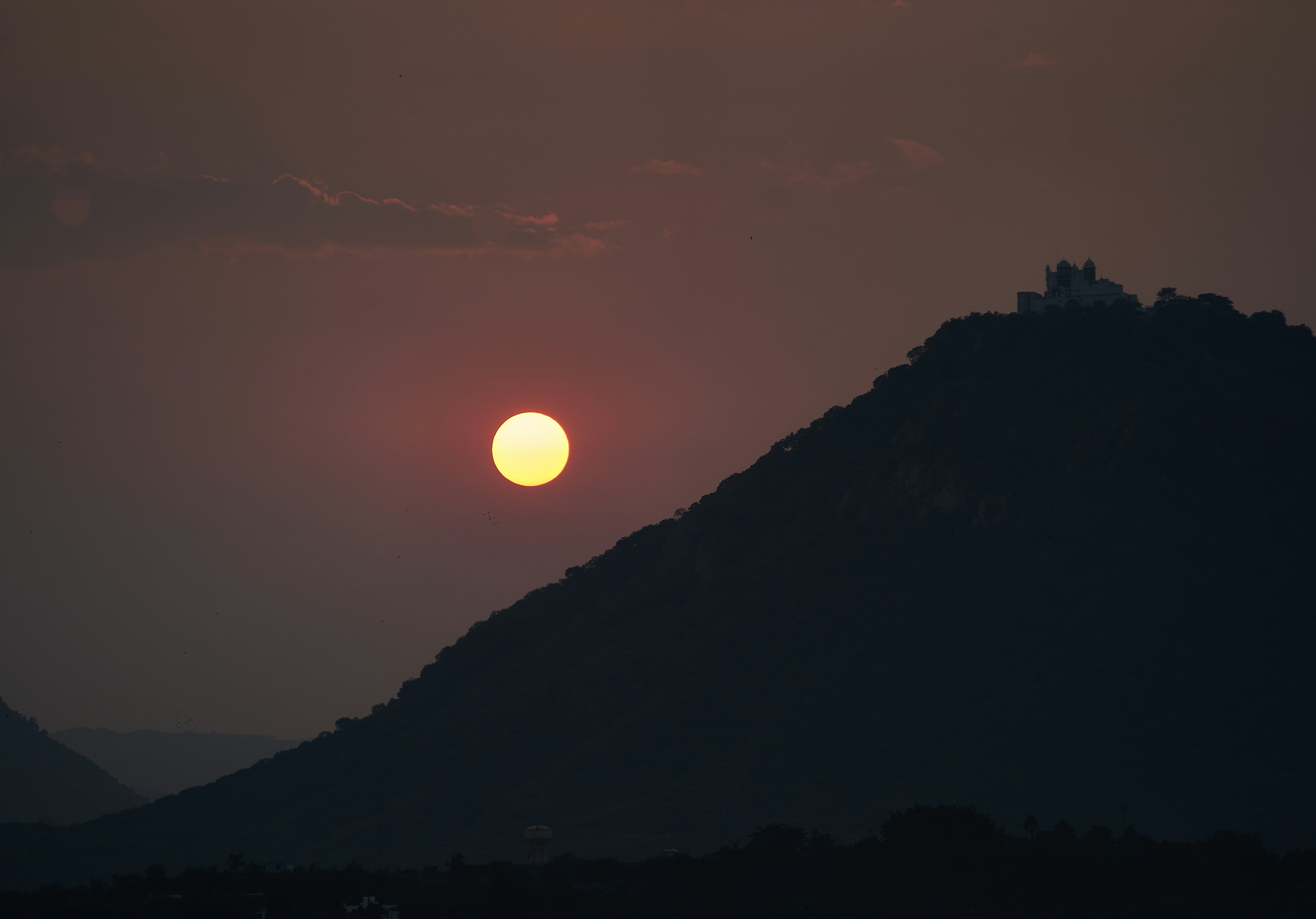 Dusk Sun Above a Silent Ridge, Cloaked in Shadow