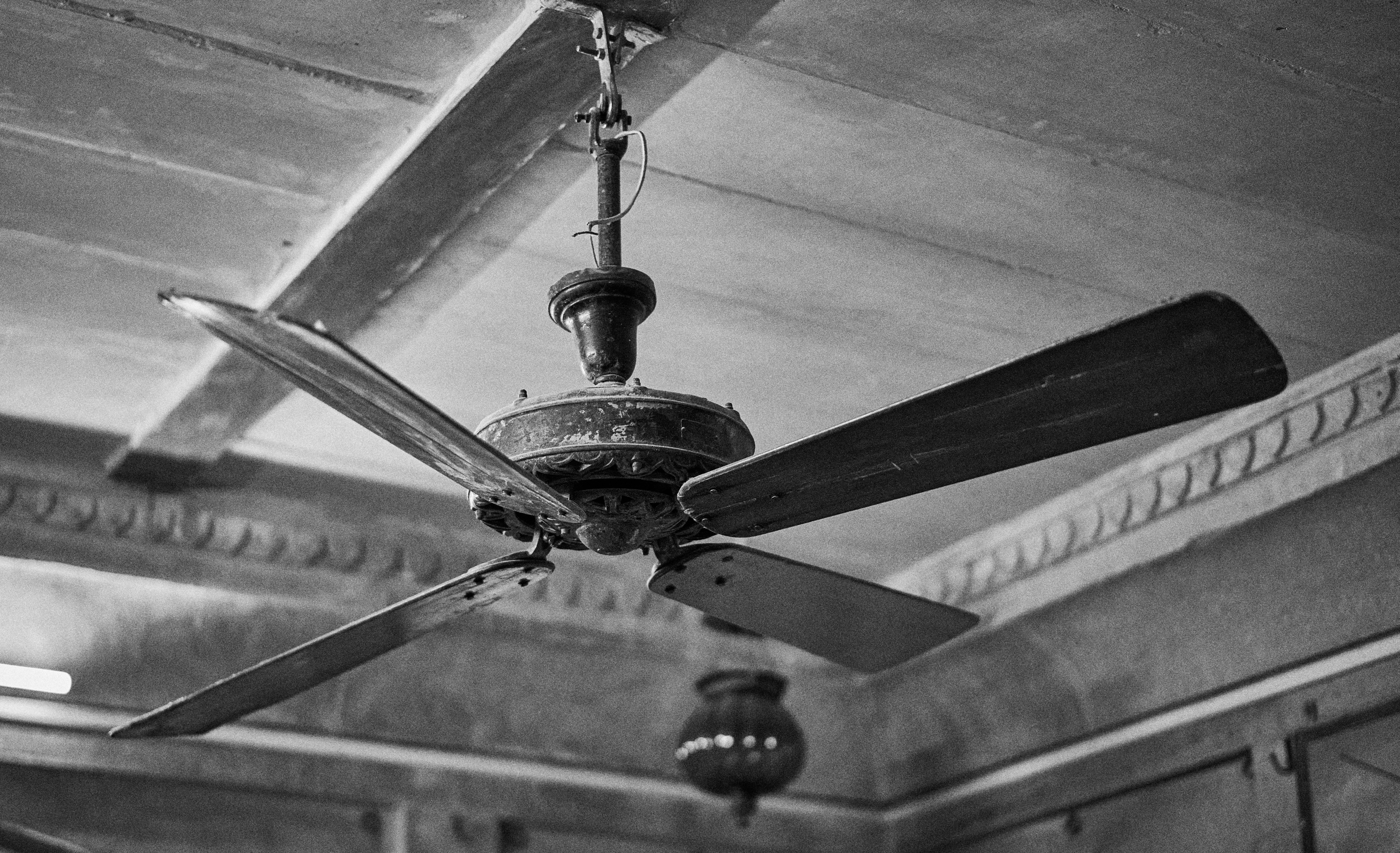 Aged Whirl: Vintage ceiling fan captured in a grainy monochrome interior