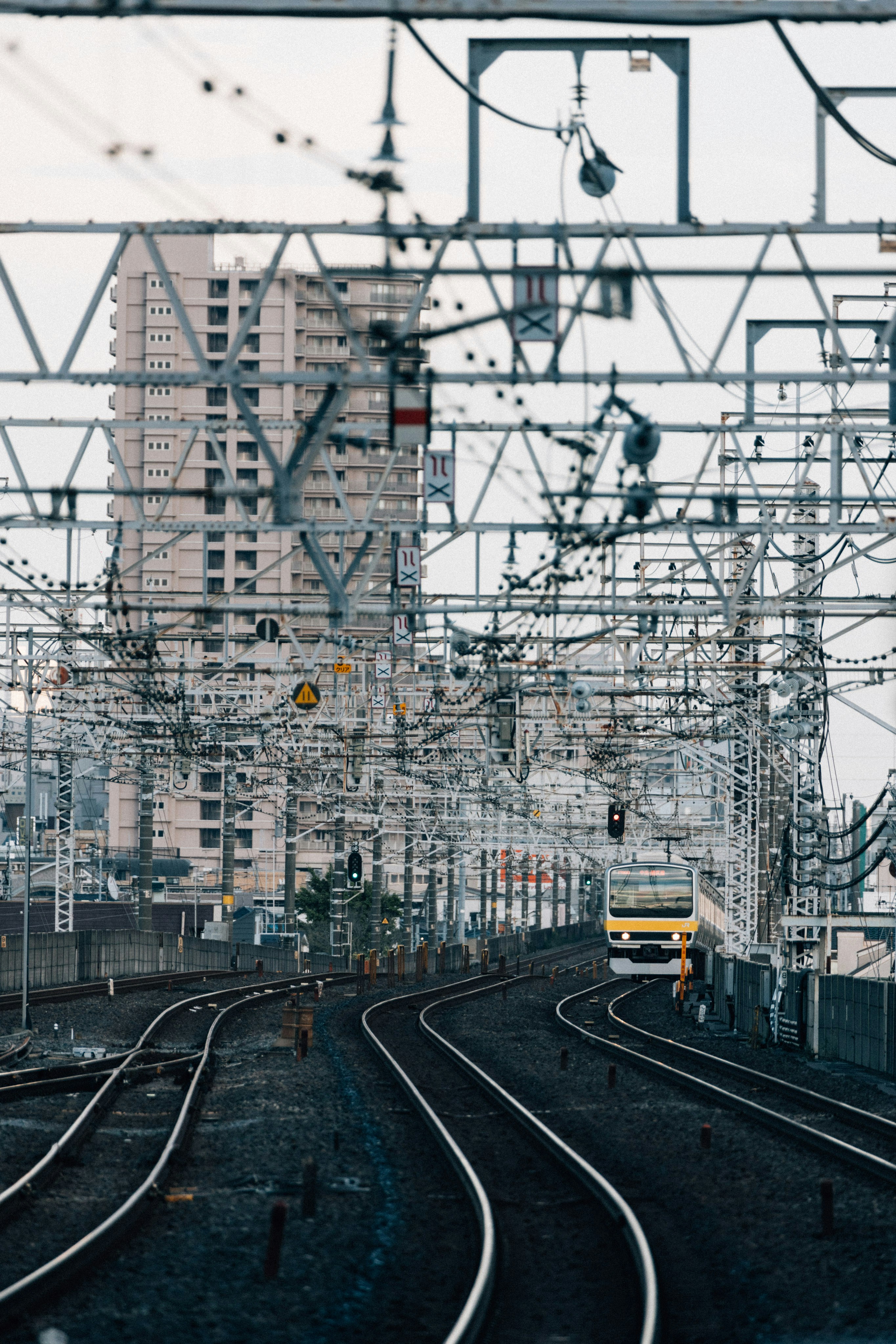 A train traveling down train tracks next to tall buildings photo – Free ...