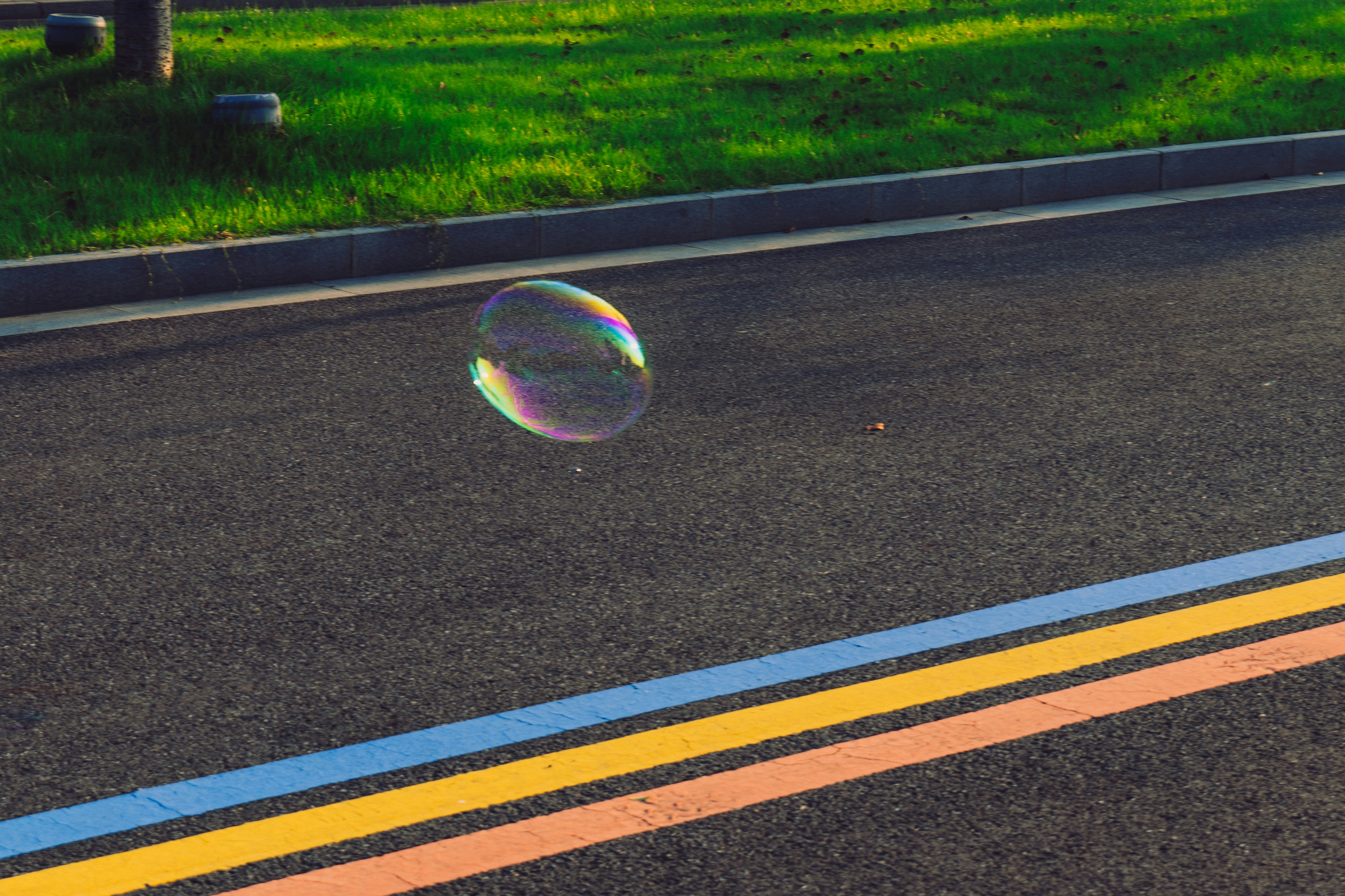 Floating Prism: A Soap Bubble Drifting Over a Painted Road