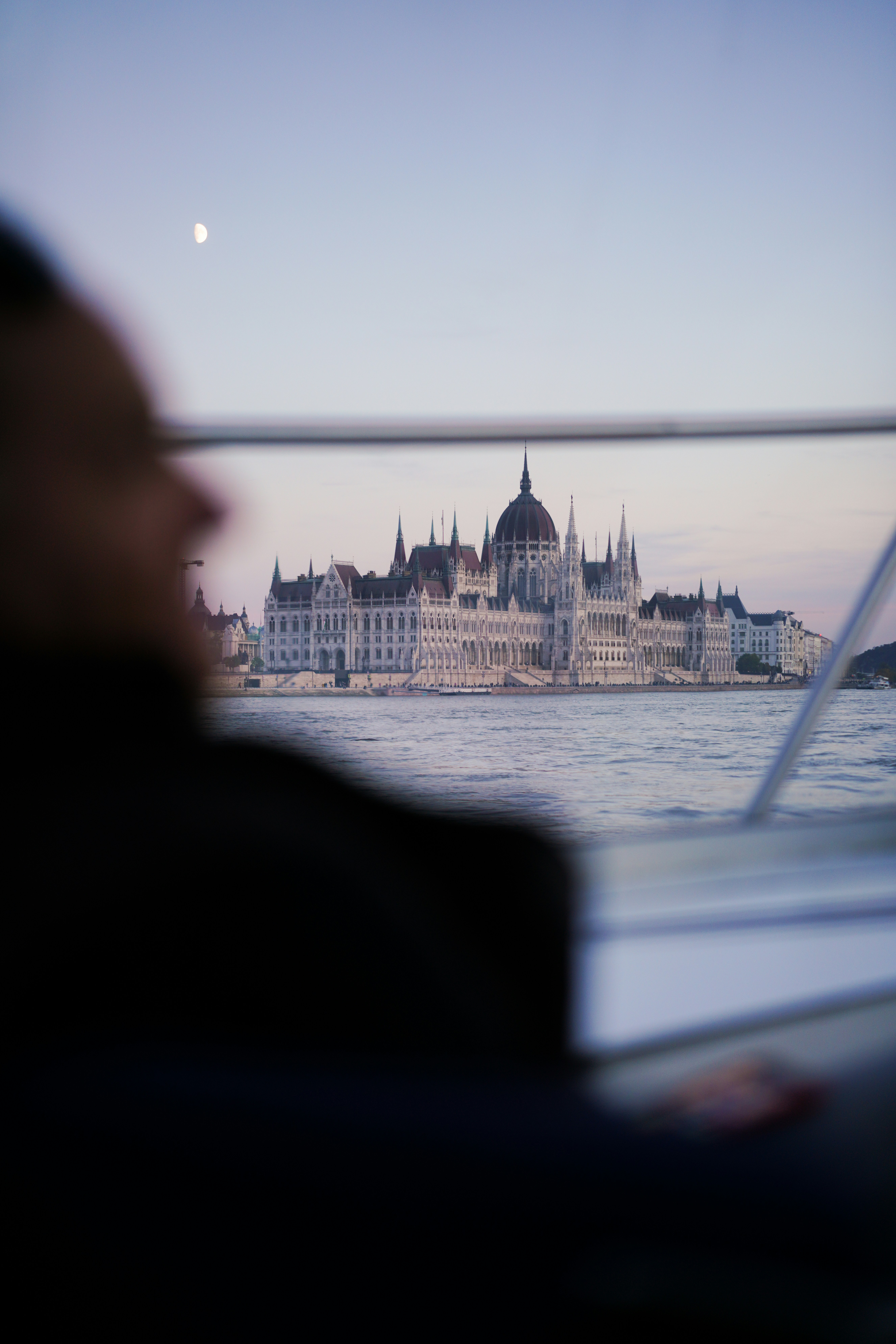 Distant Parliament Arches Across the Water, Framed by a Blurred Vessel Interior