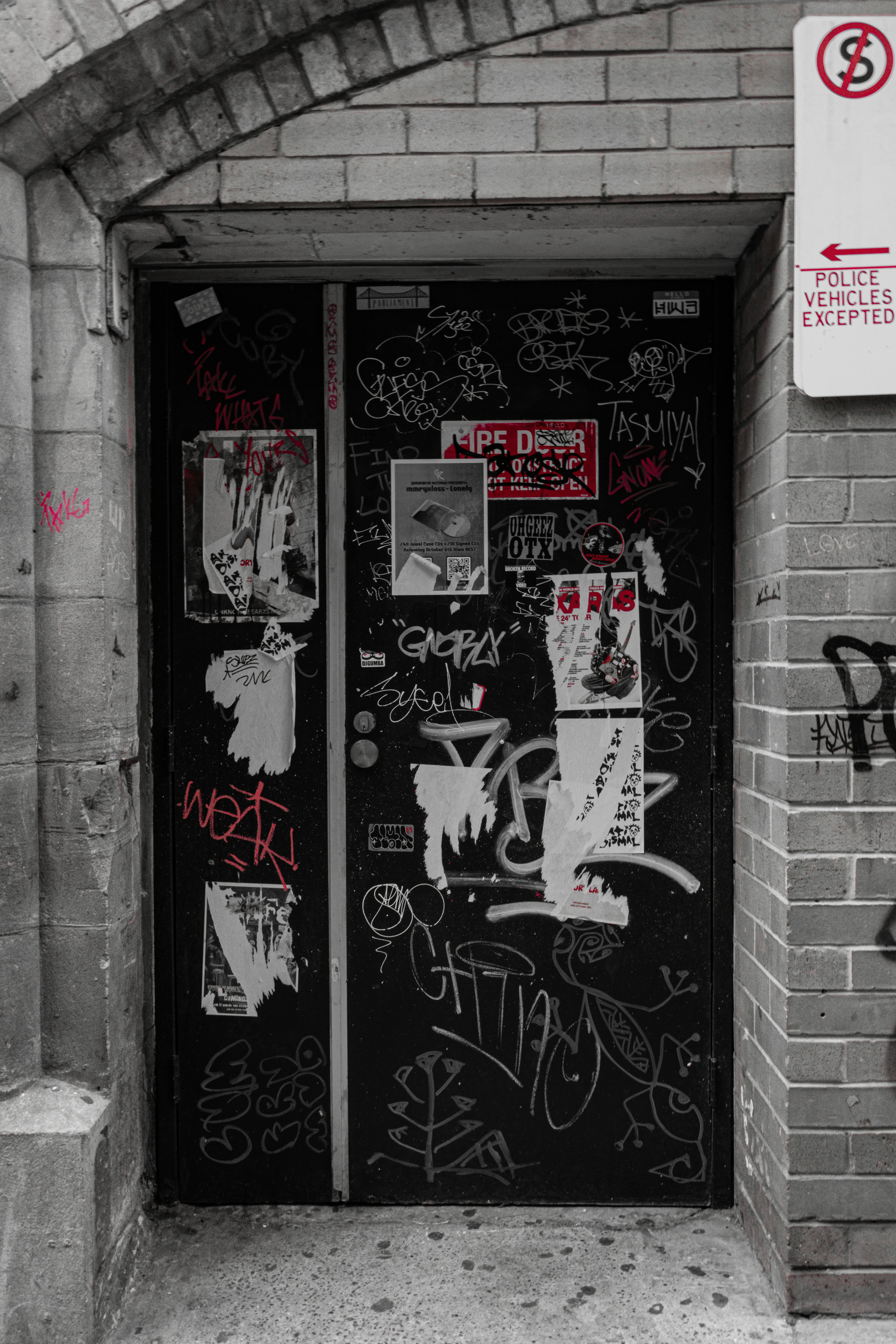 A black and white photo of a door covered in graffiti photo – Free ...