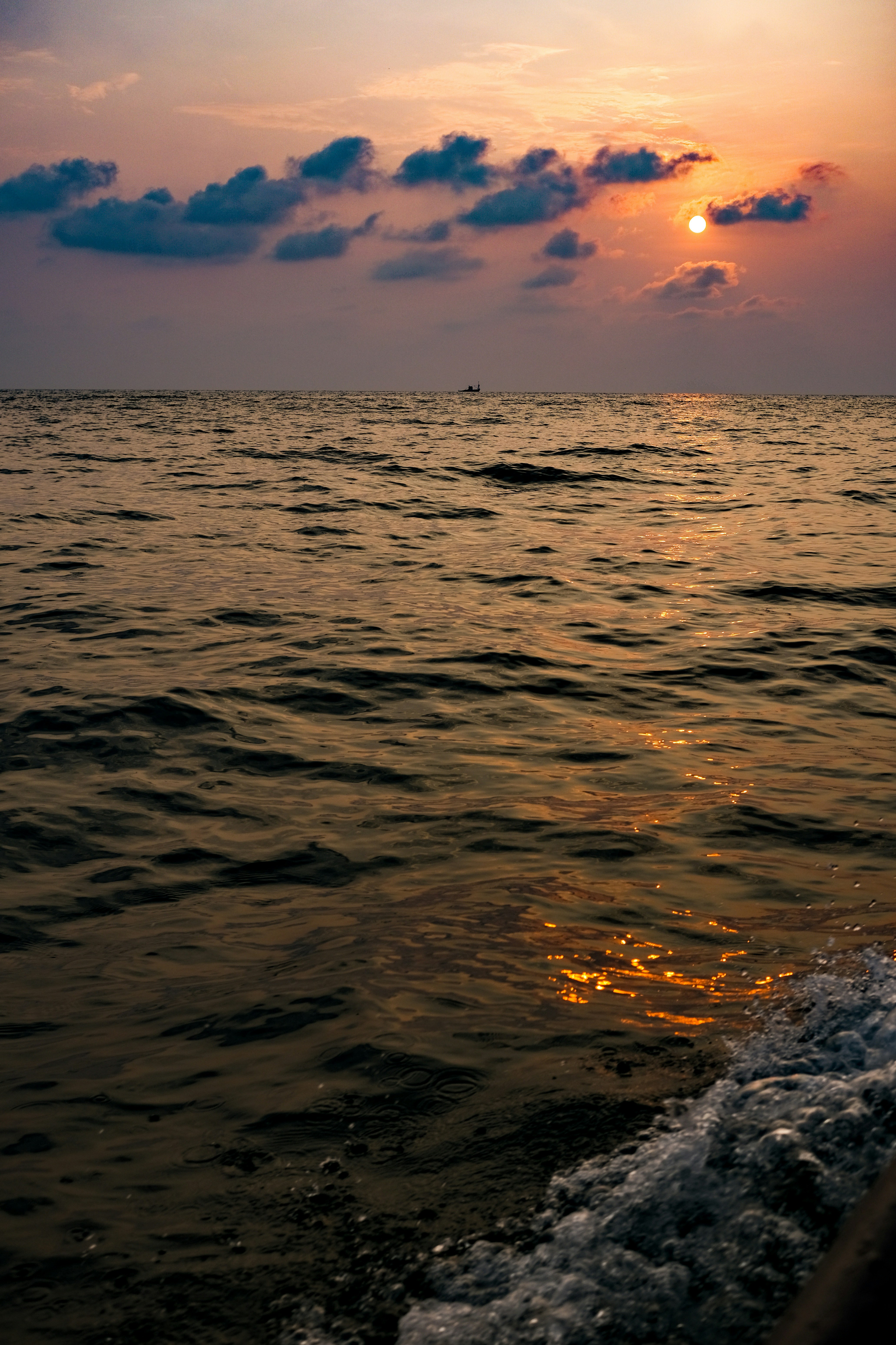Sunbound Horizon: A Lone Boat Silhouetted Against a Copper Ocean at Dusk.