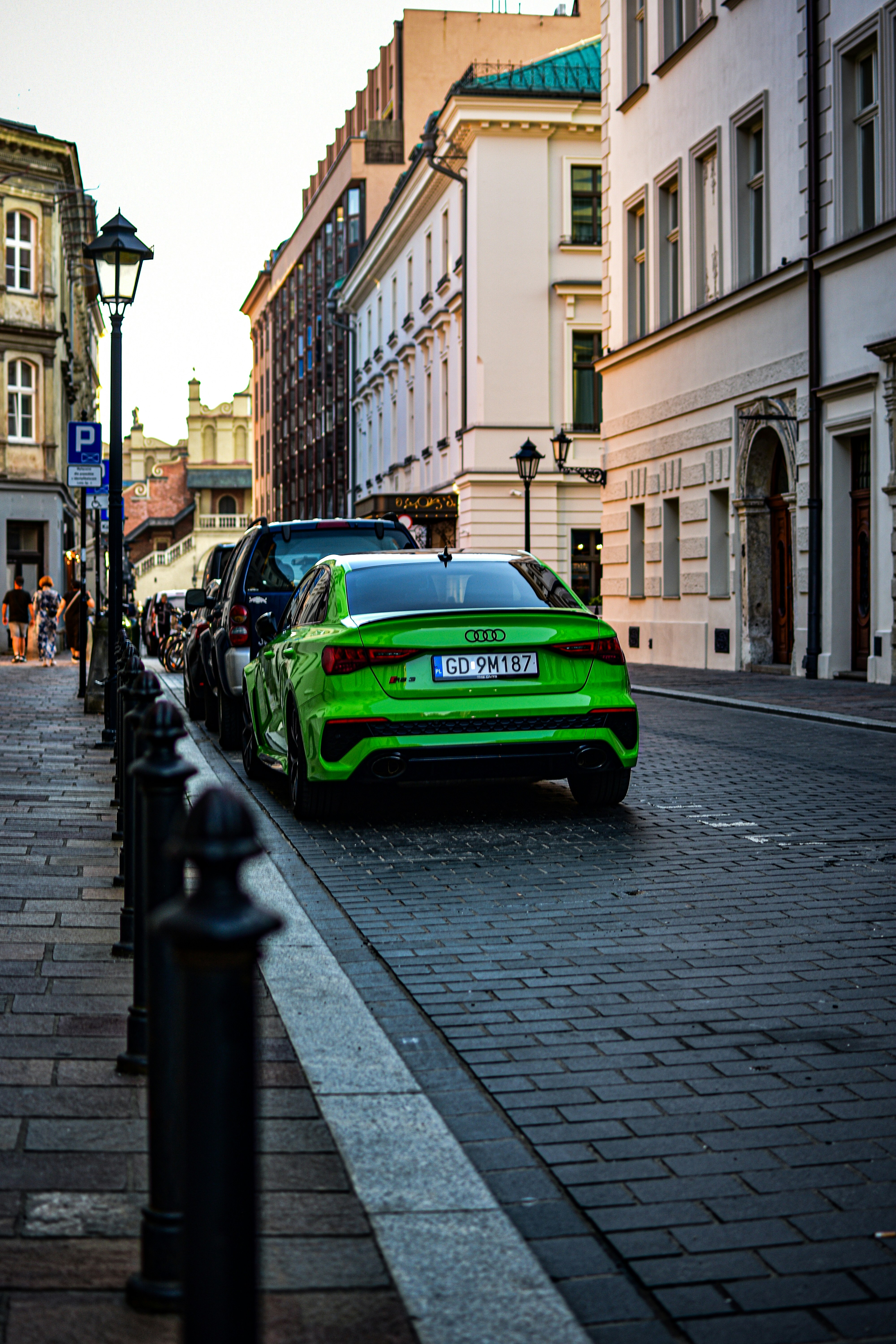 Lime-green Audi on a sunlit cobblestone European street